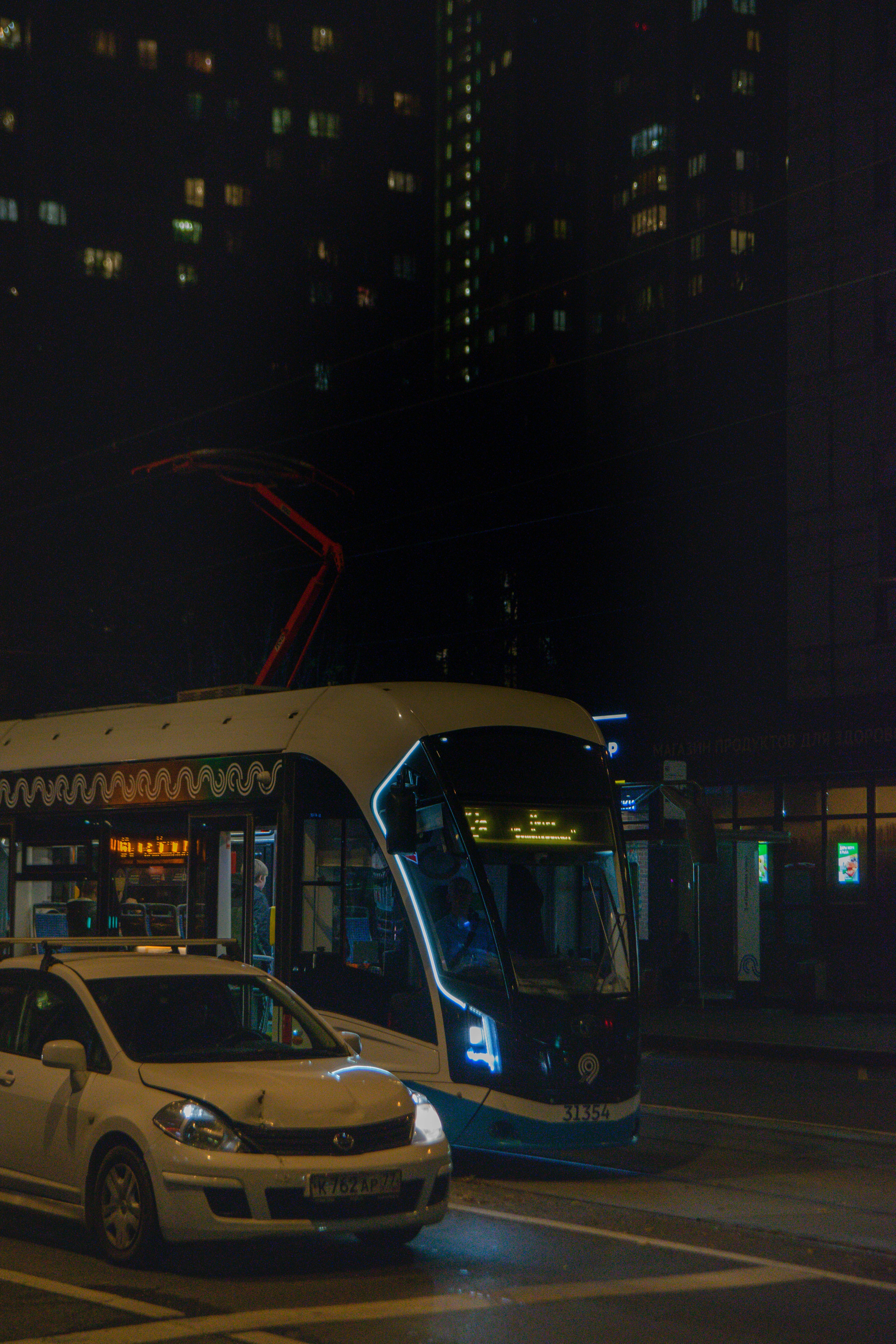 Nighttime Transit: Tram Meets Street in Neon Shadow