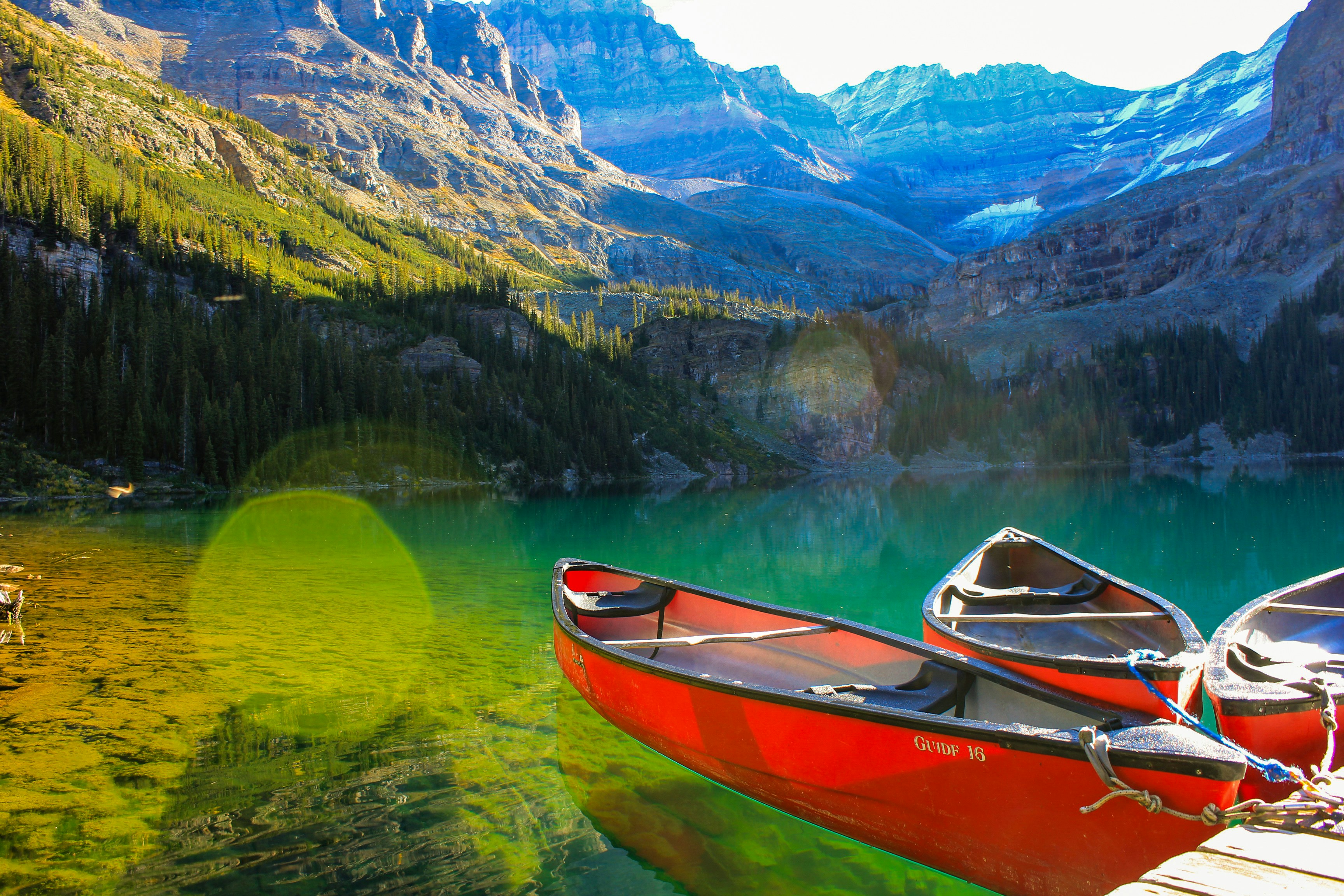 Crimson Canoes Framing an Emerald Alpine Lake