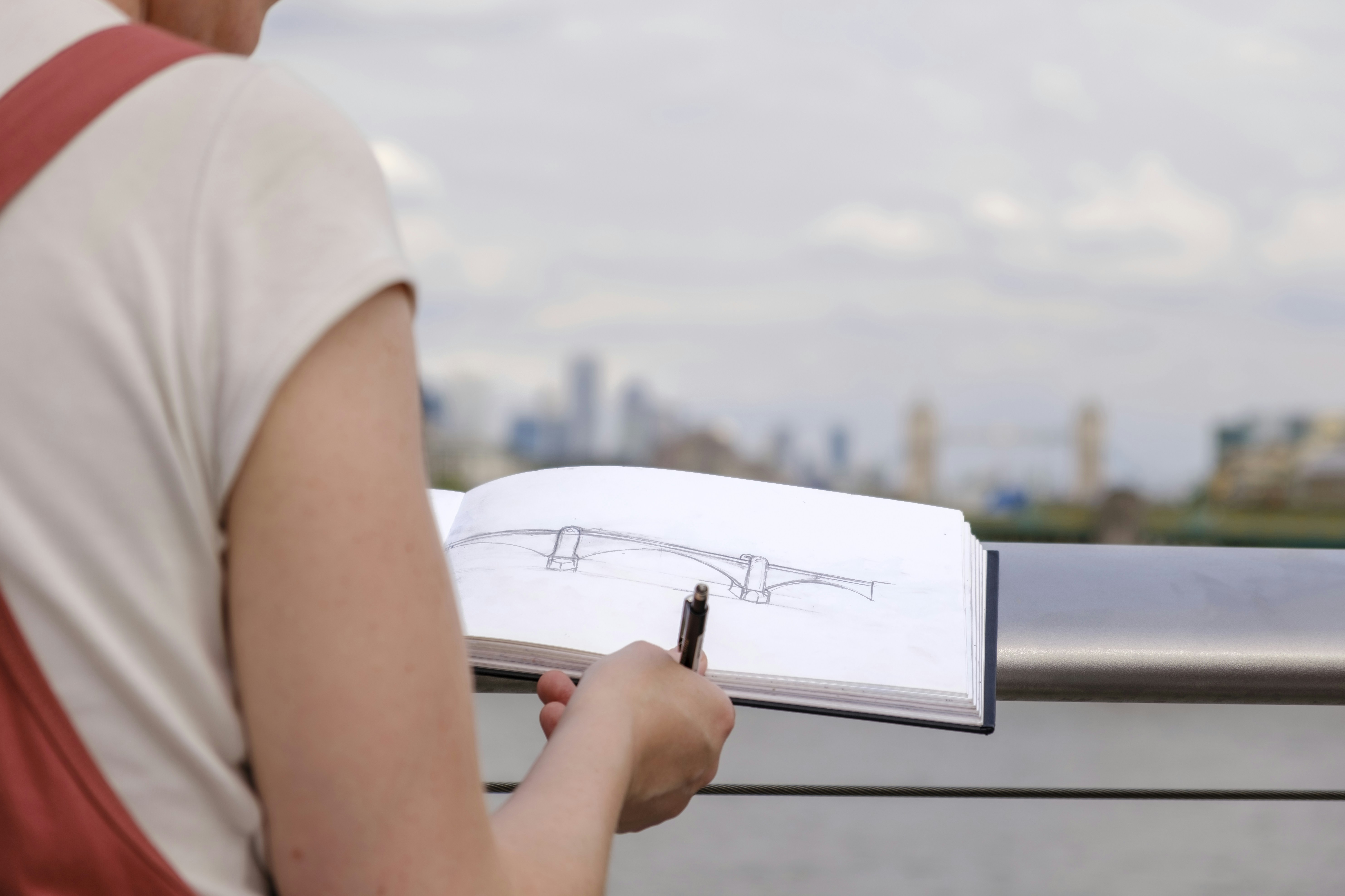A girl drawing London Tower Bridge in front of the bridge