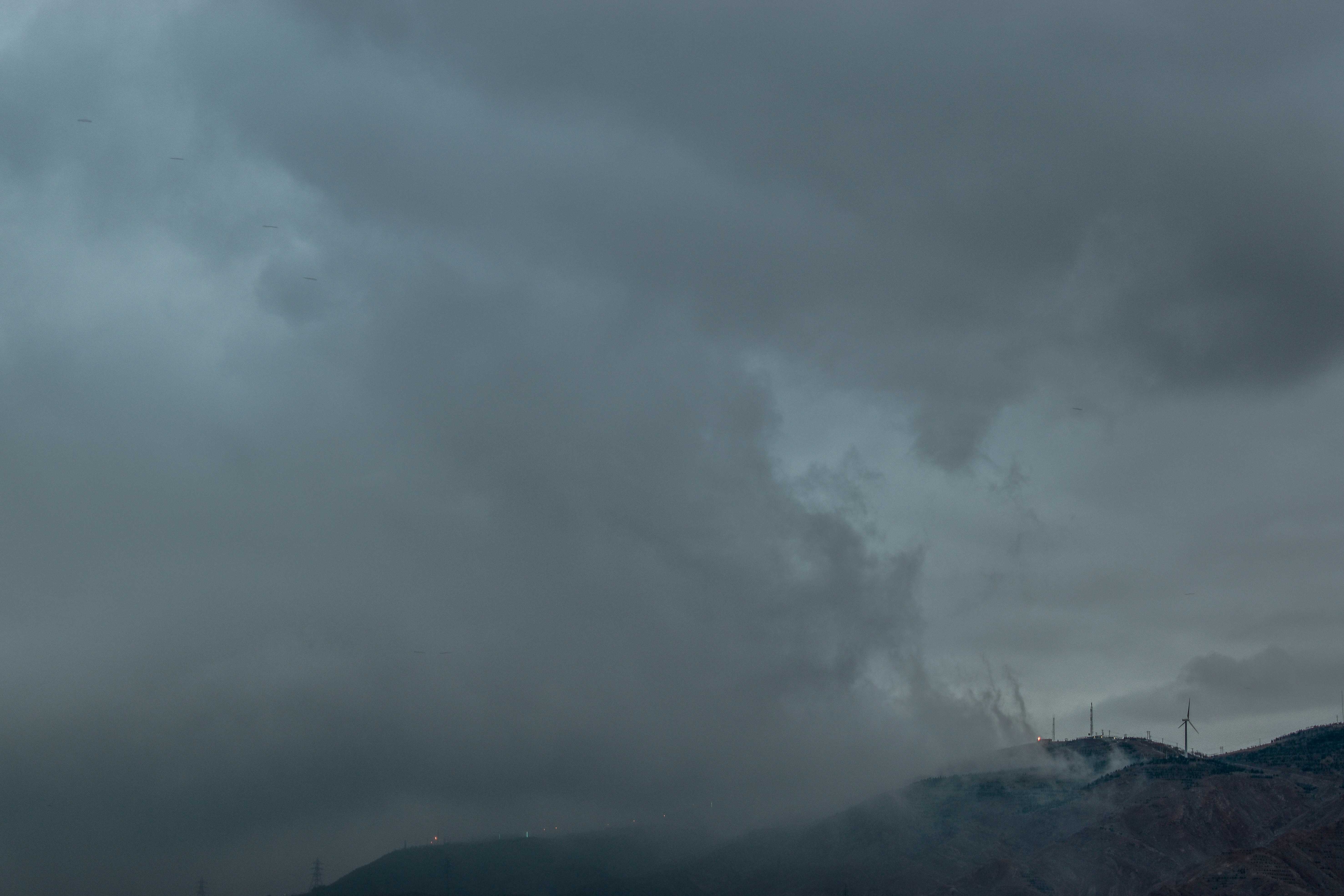 Ridgeline of Wind and Cloud: Turbines Stand Against the Storm