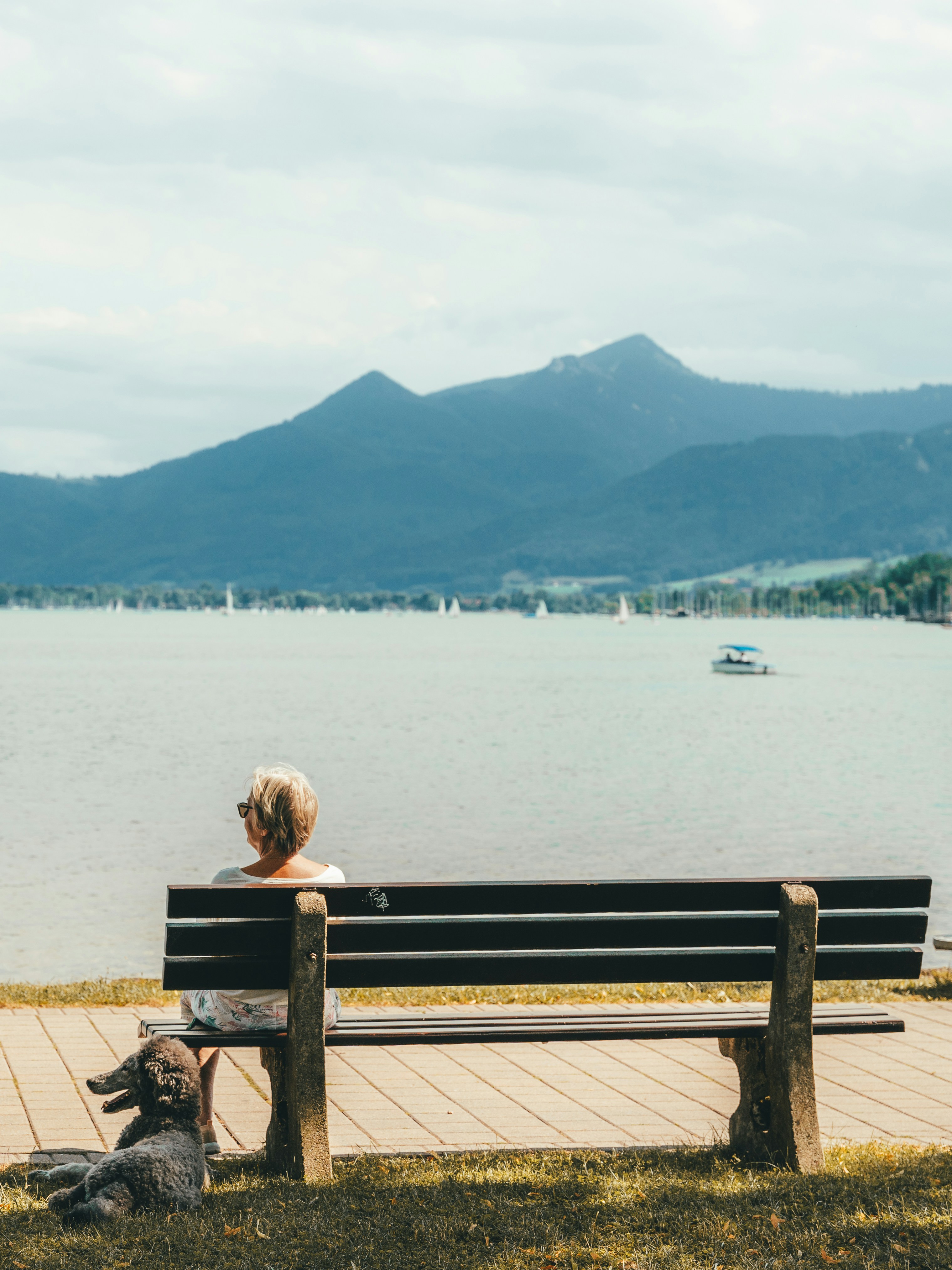 Une personne assise sur un banc devant un plan d’eau photo – Photo Meubles Gratuite sur Unsplash