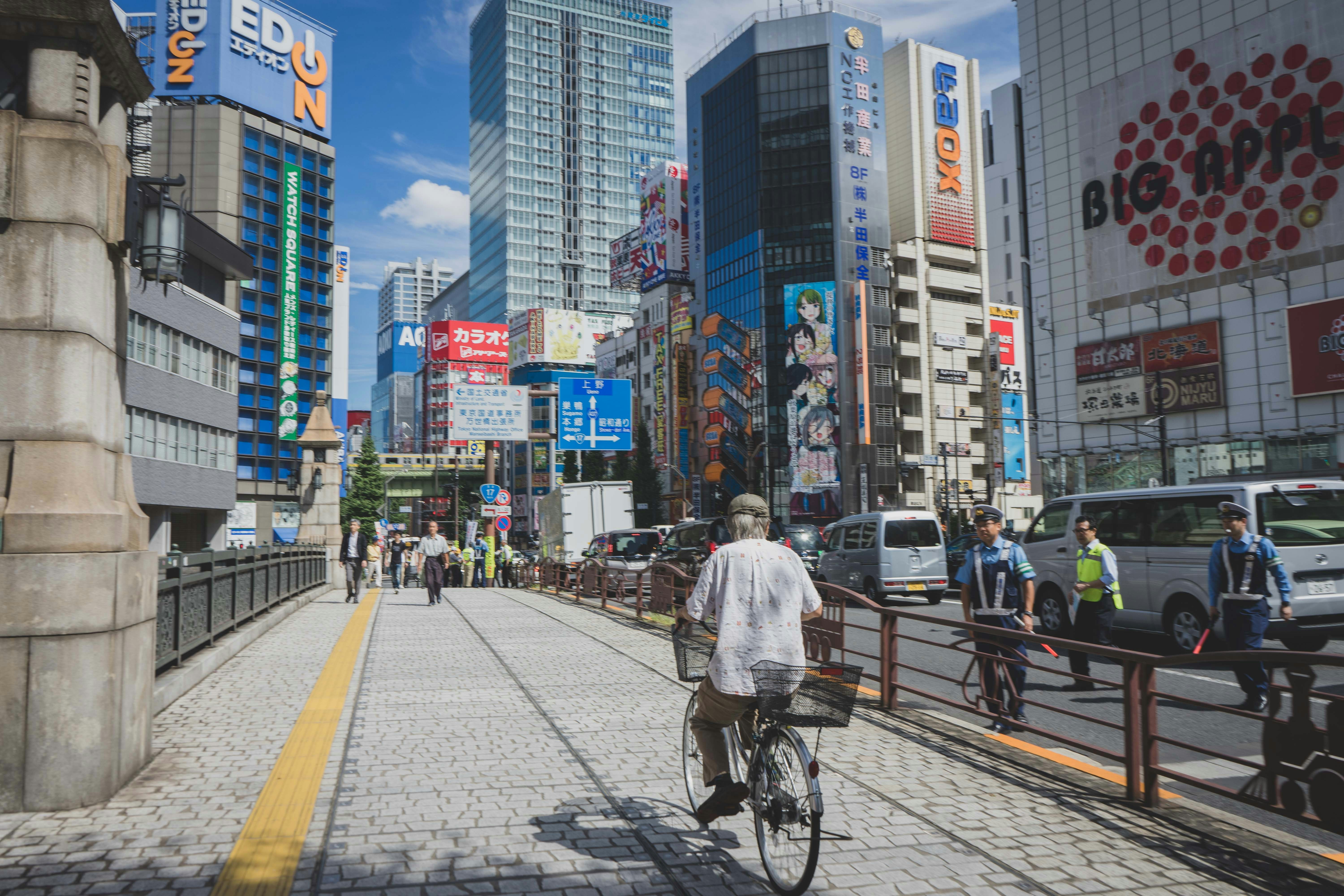 Cyclist Amid Neon Towers: A City Street in Motion