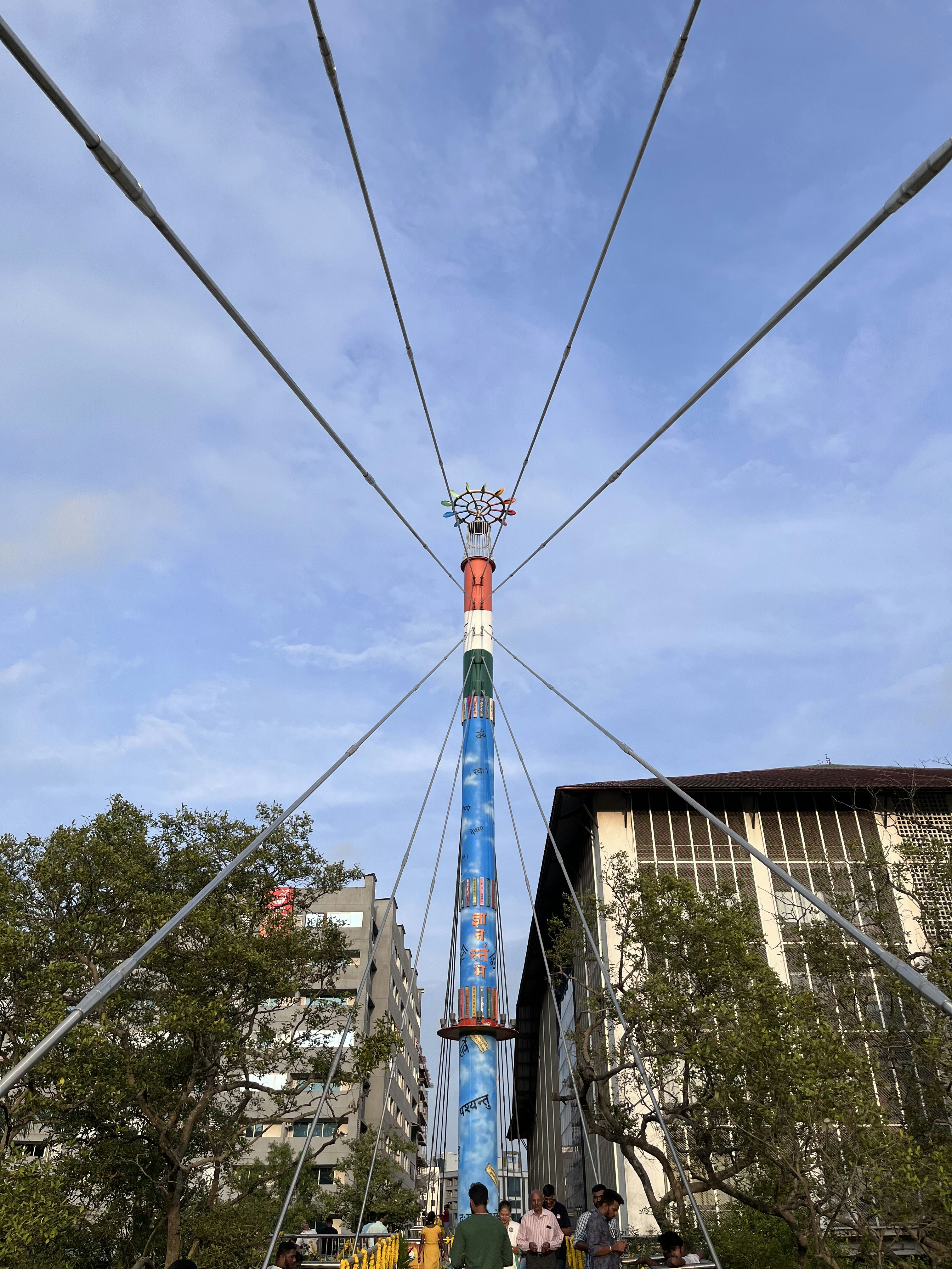 Rainbow Spire Adorned by Radial Cables in a City Plaza