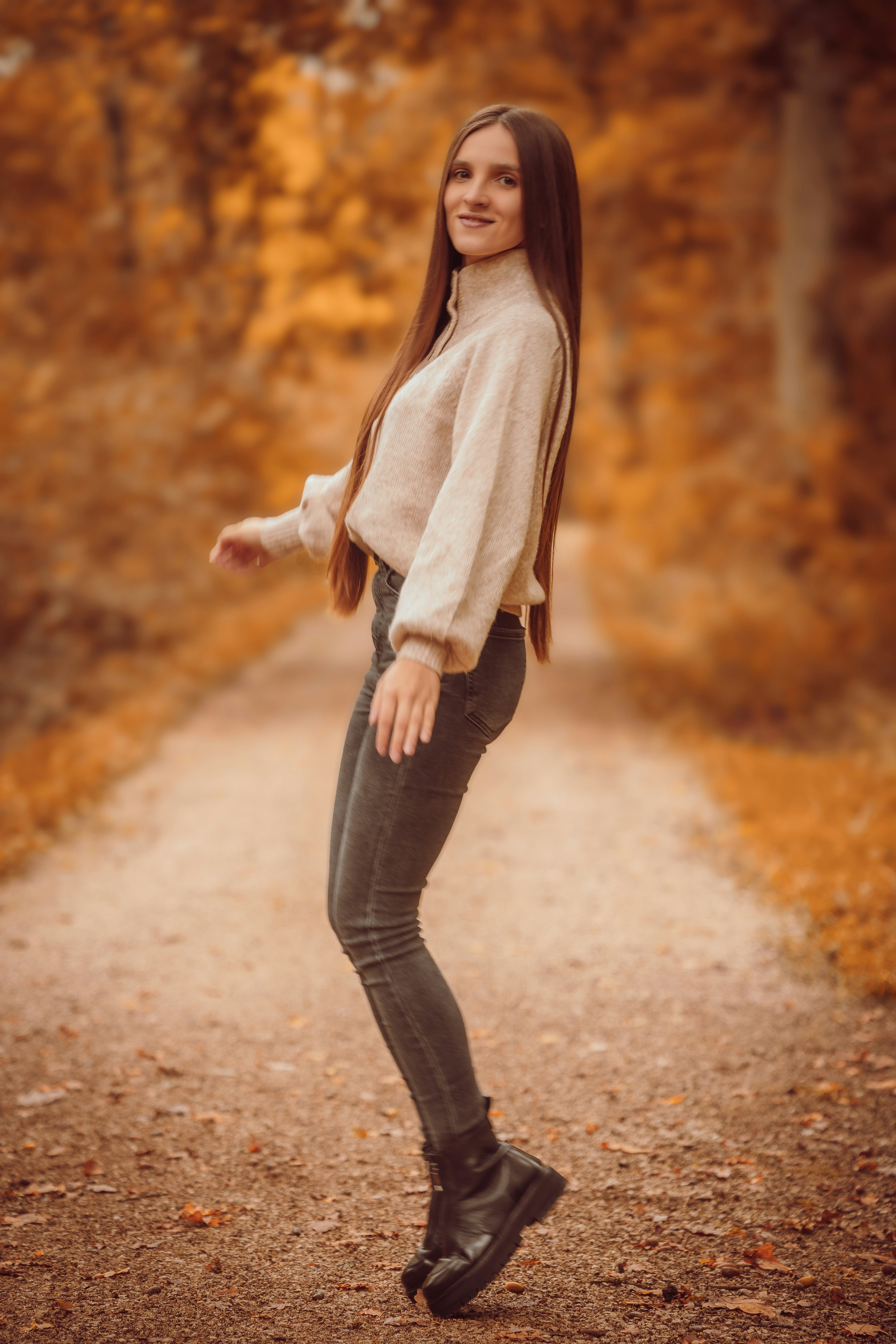 Foto Una persona parada en un camino con árboles a ambos lados del ...