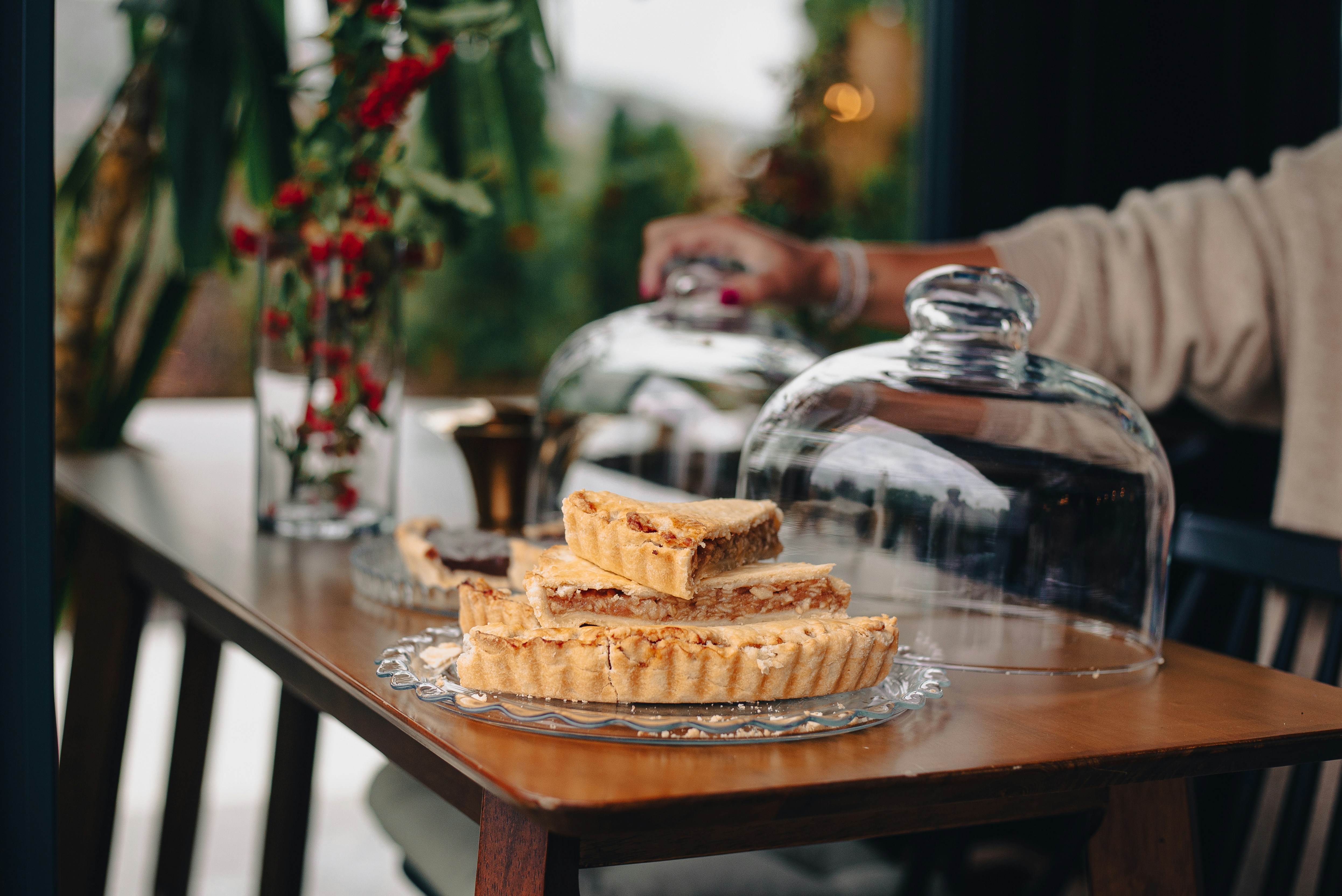 A Quiet Stack of Tarts Beneath a Glass Dome in a Cozy Café
