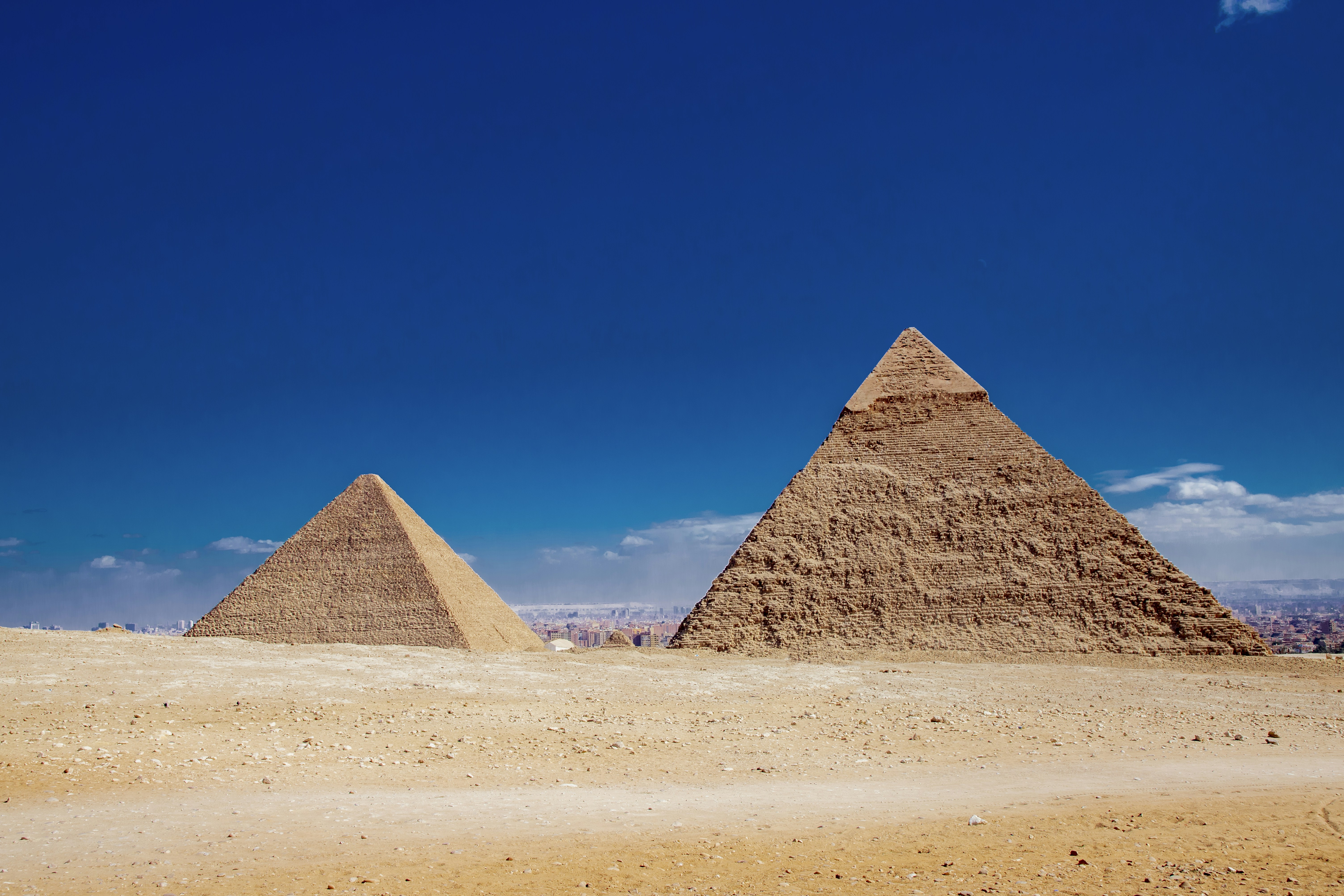 A couple of pyramids in a desert with Giza pyramid complex in the ...