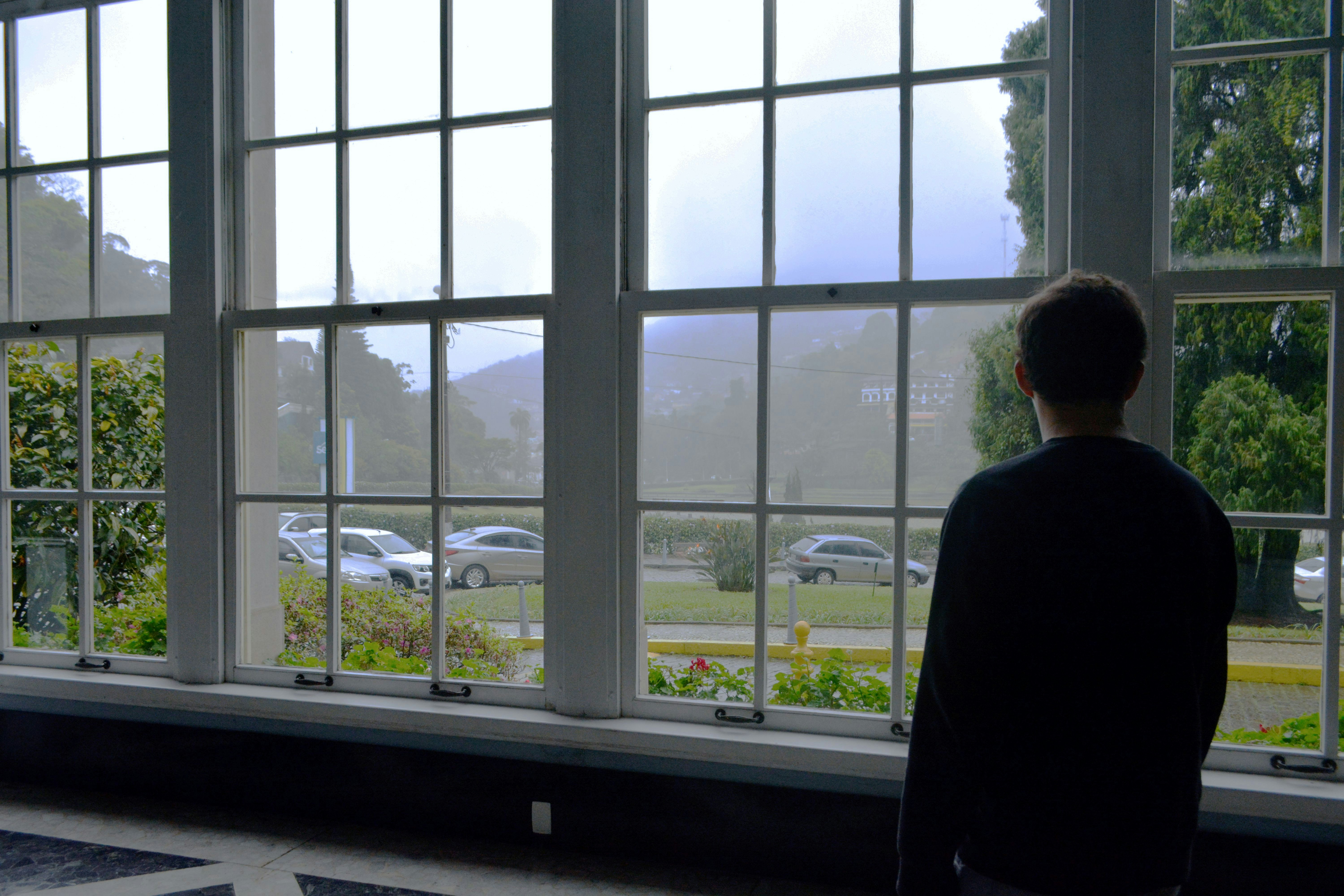 A person looking out a window photo – Free Quitandinha Image on Unsplash