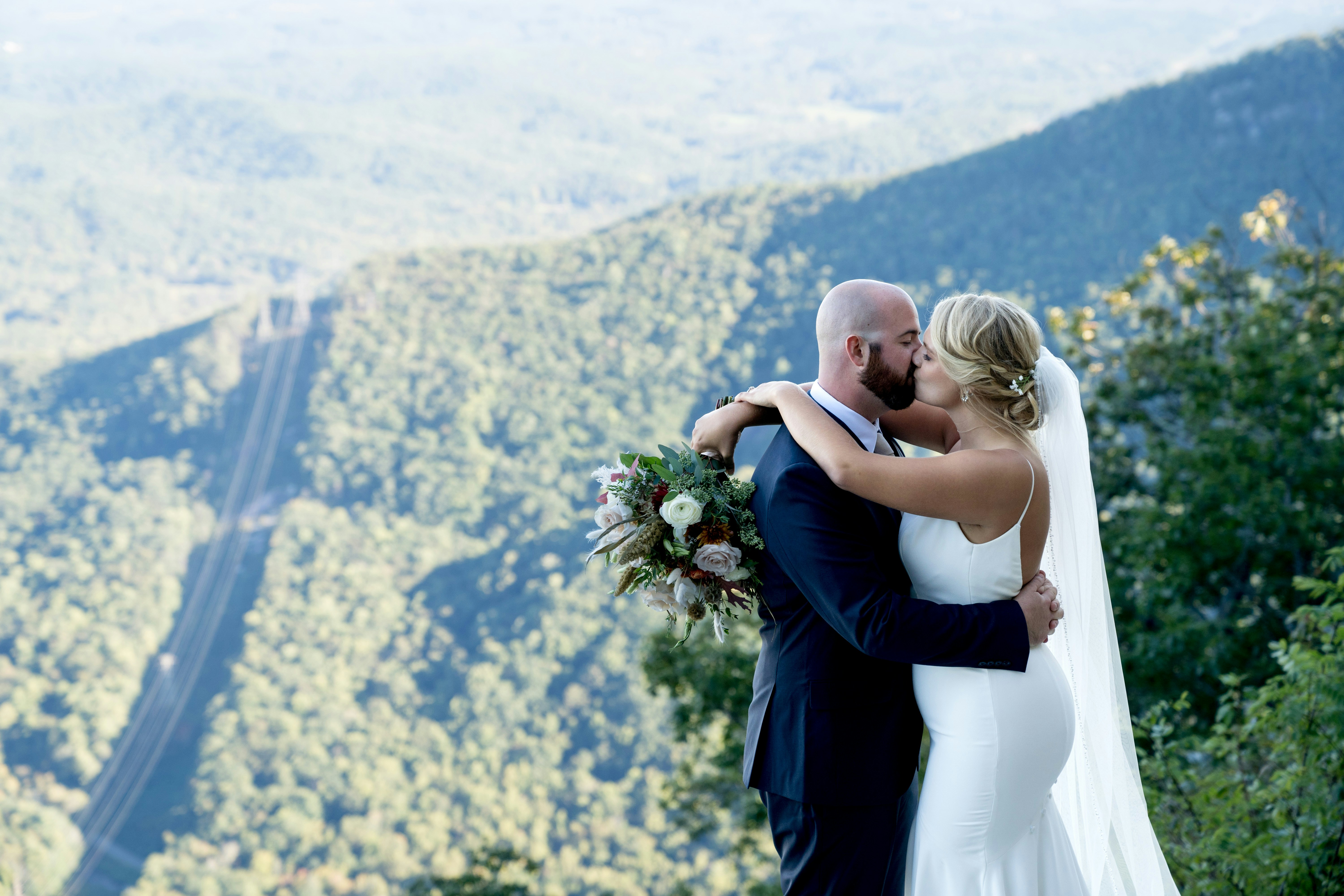 A man and woman kissing on a hilltop overlooking a valley photo – Free ...