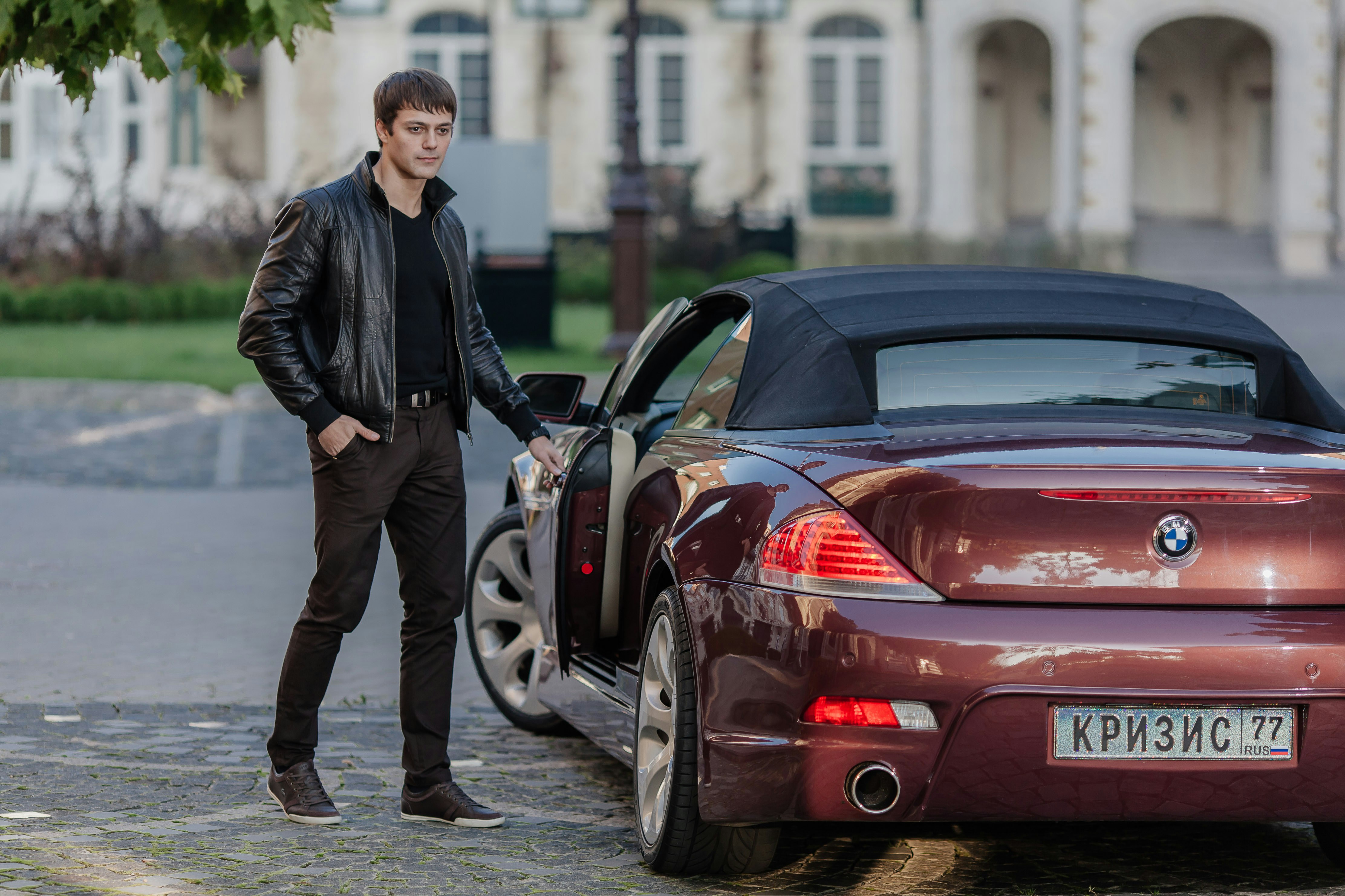 Leather-Clad Moment: A Red BMW Roadster Opens on a Quiet Cobblestone Street
