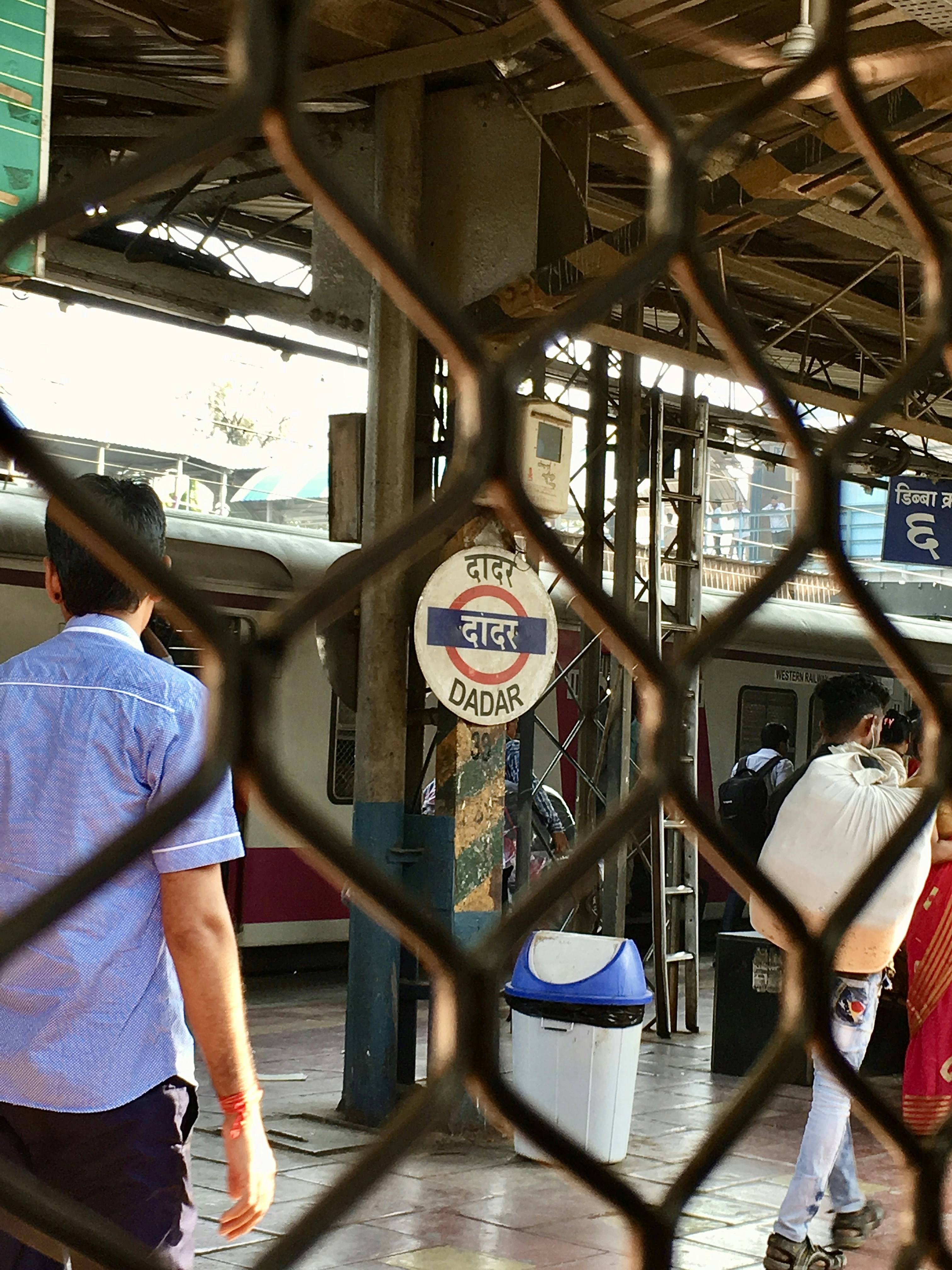 Dadar Sign Through Diamond Mesh: A Mumbai Platform Moment