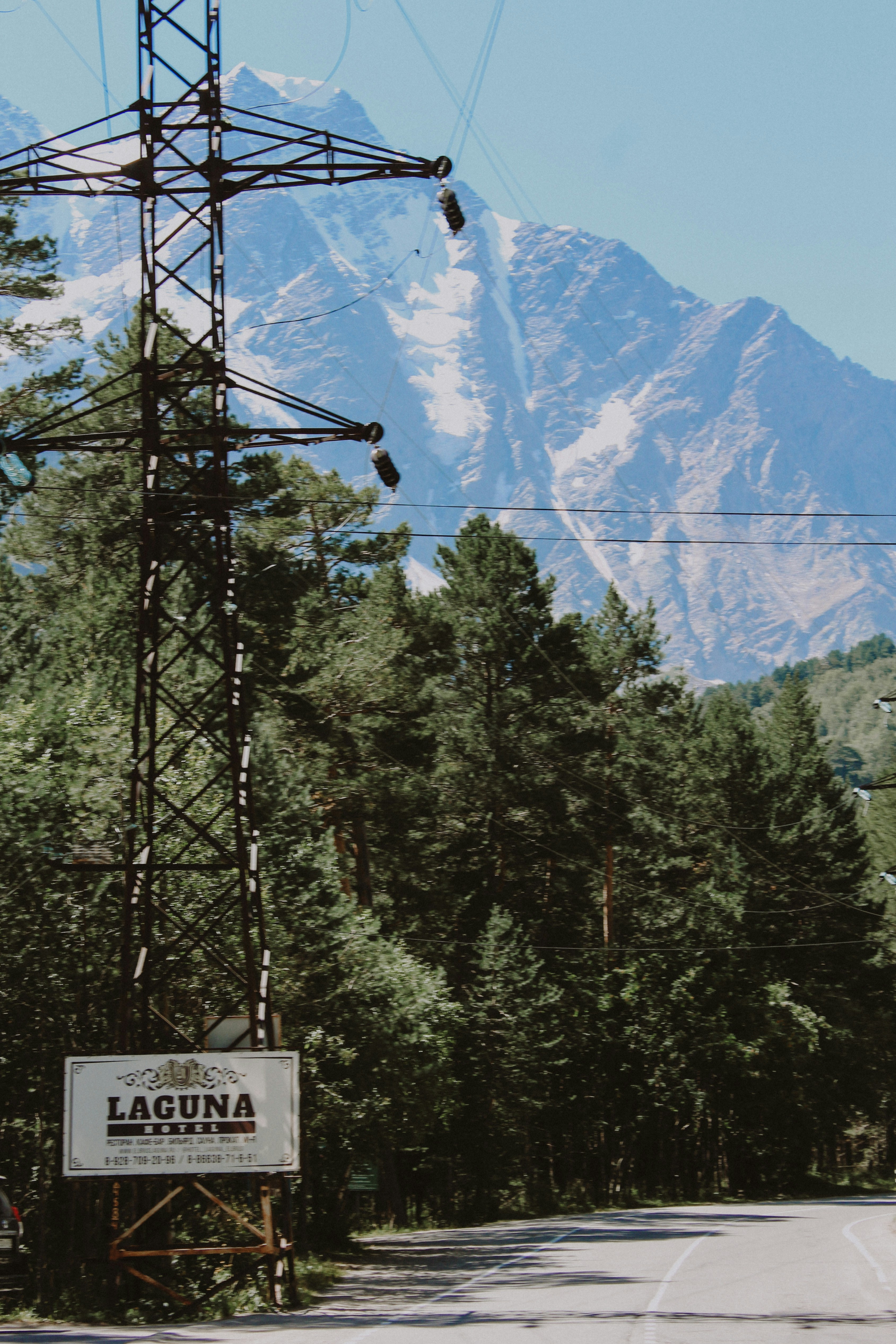 Power lines to peaks: a roadside frame beneath jagged mountains