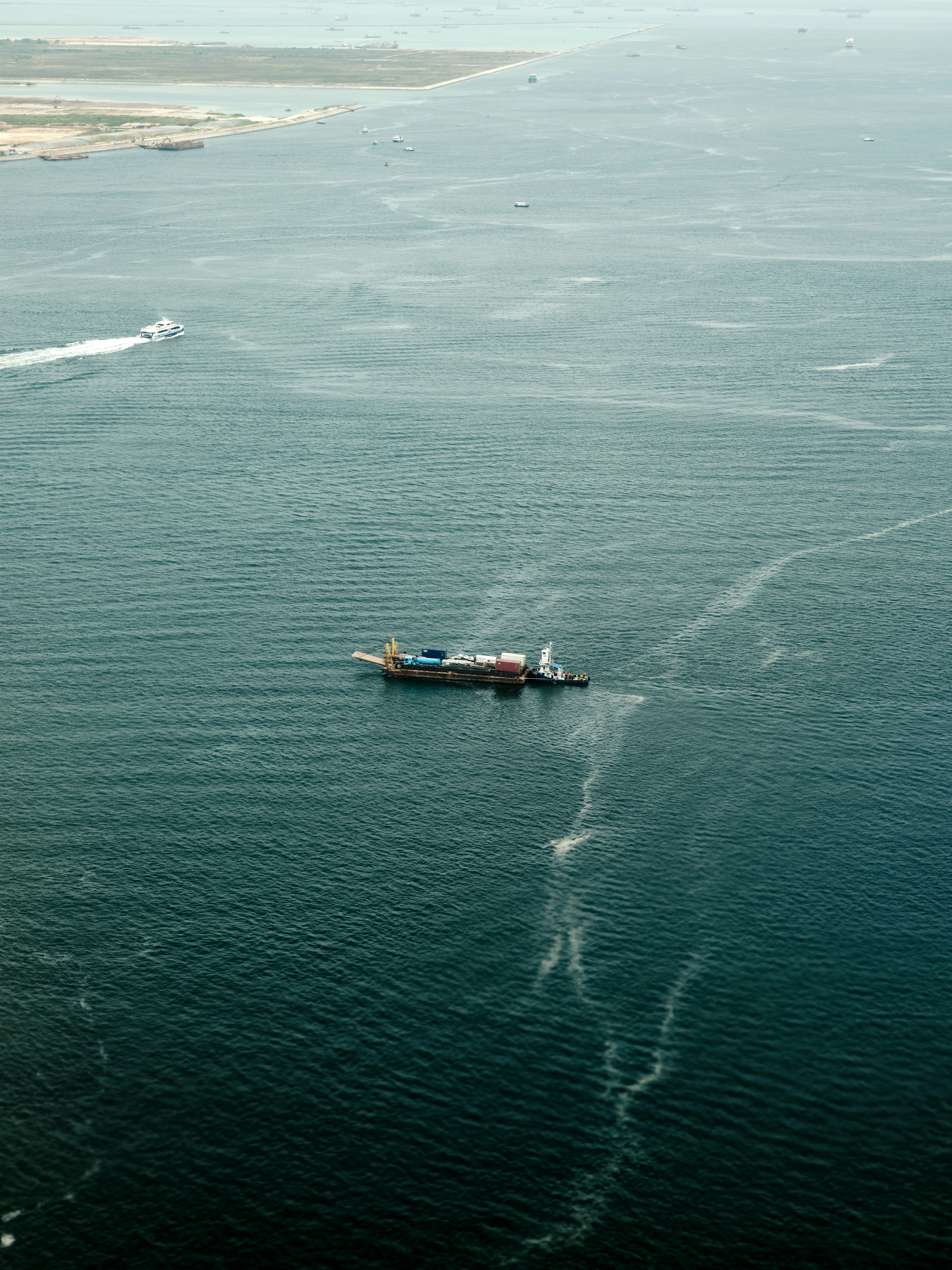 Aerial View: Solitary Cargo Barge Pierces a Calm Blue Sea