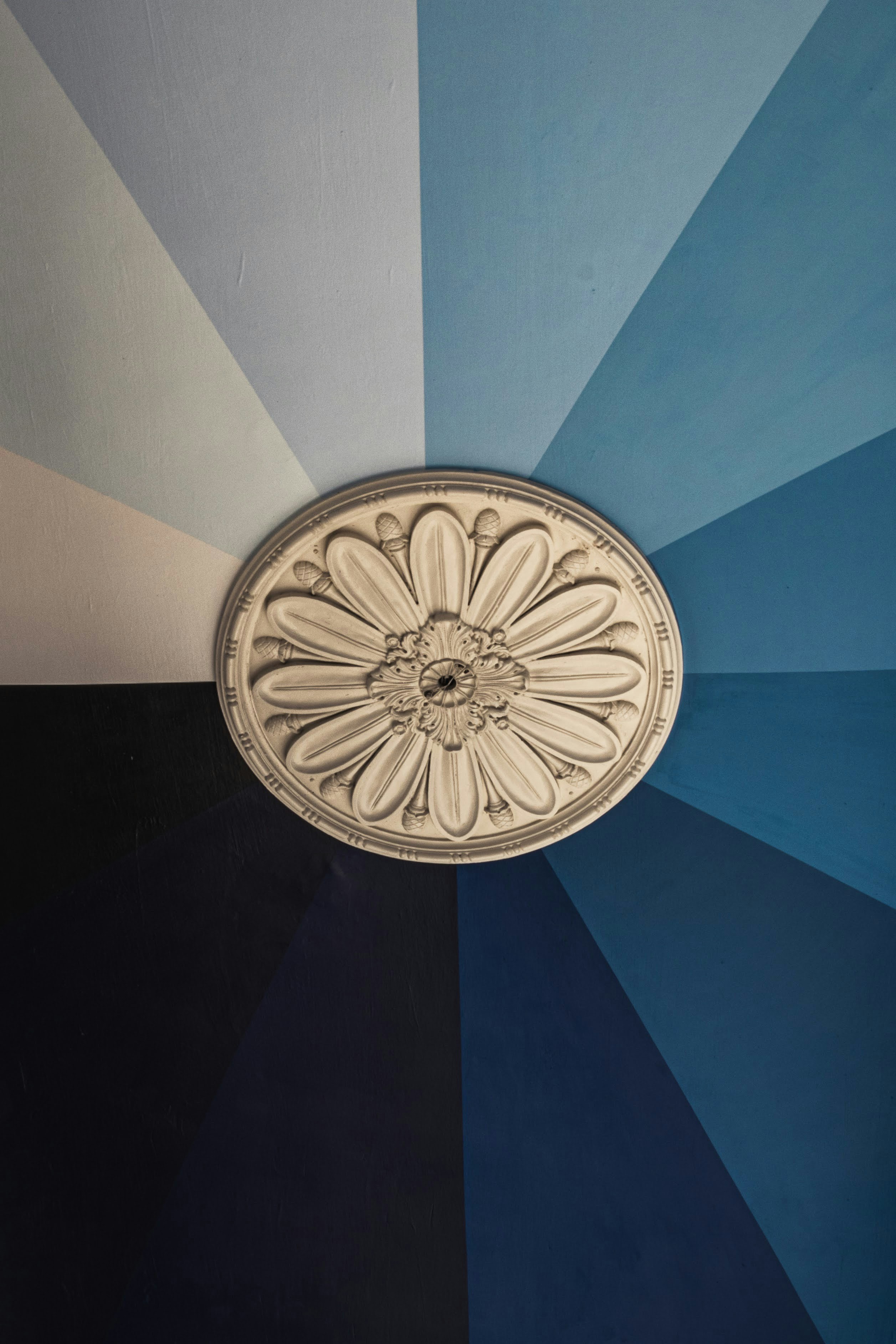Centerpiece in a Blue Sunburst: A Floral Ceiling Medallion at the Heart of the Room