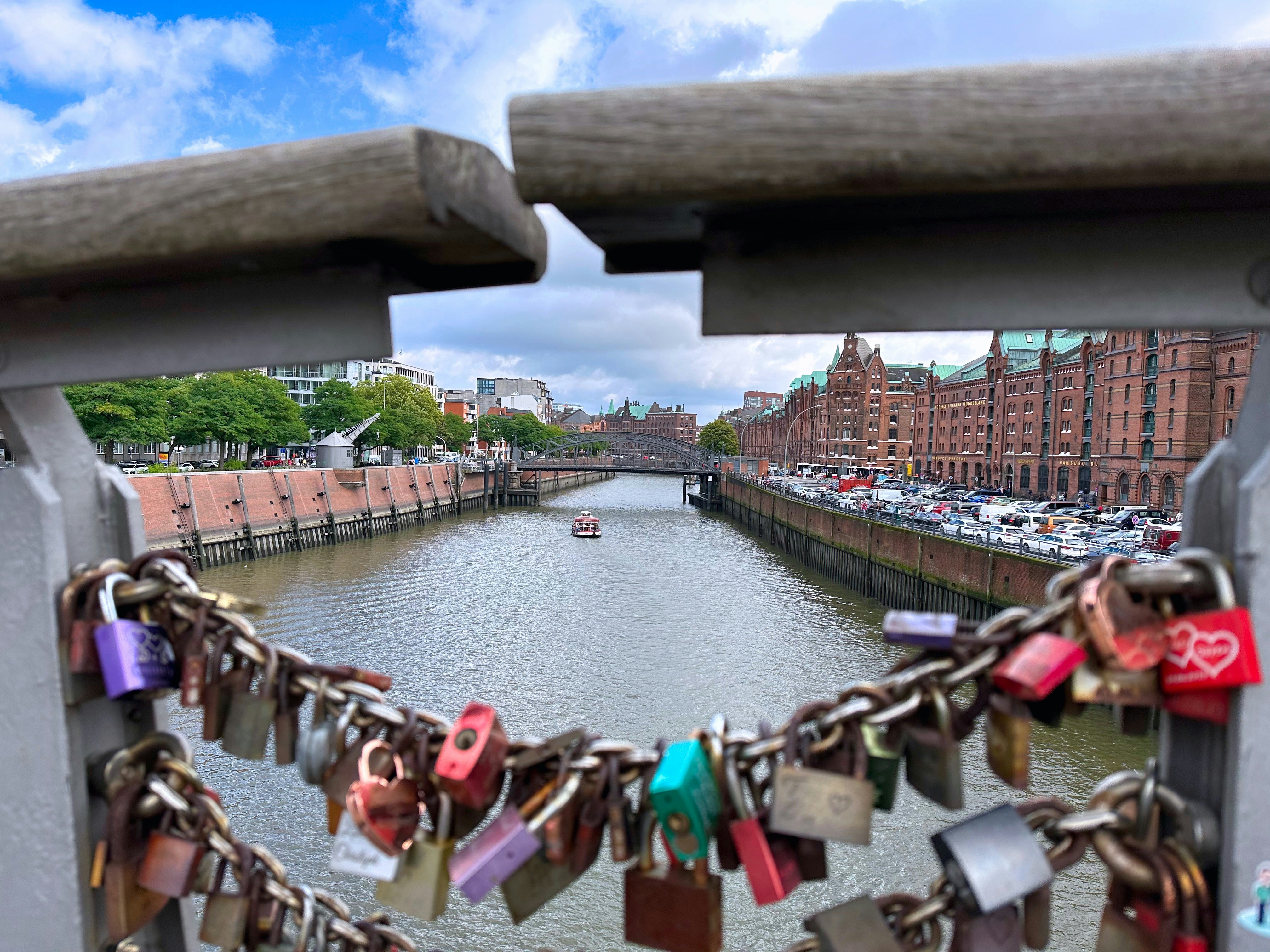 Locks on a Canal Bridge Framing a Brick-Walled City