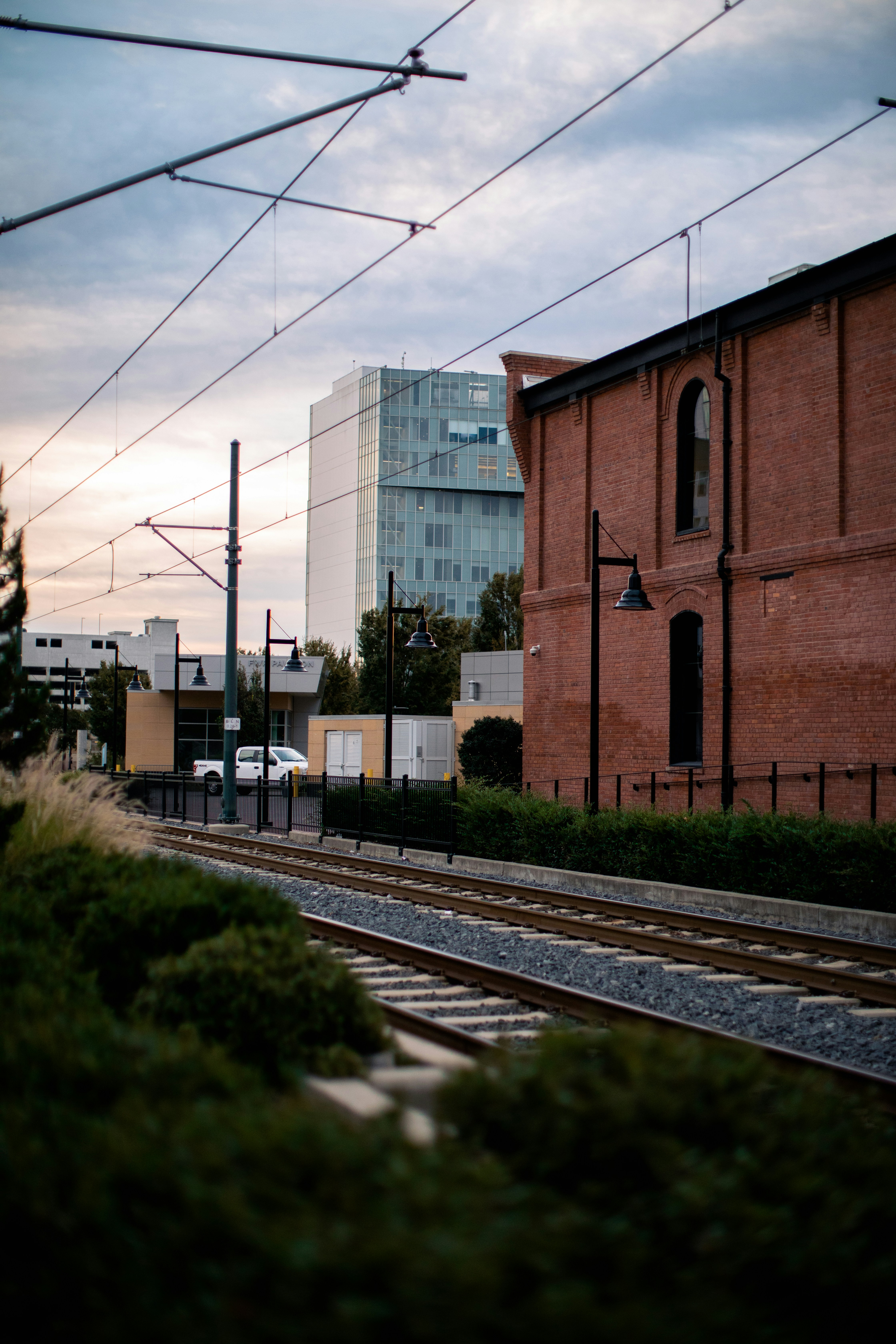 Train tracks next to a brick building photo – Free Charlotte Image on ...