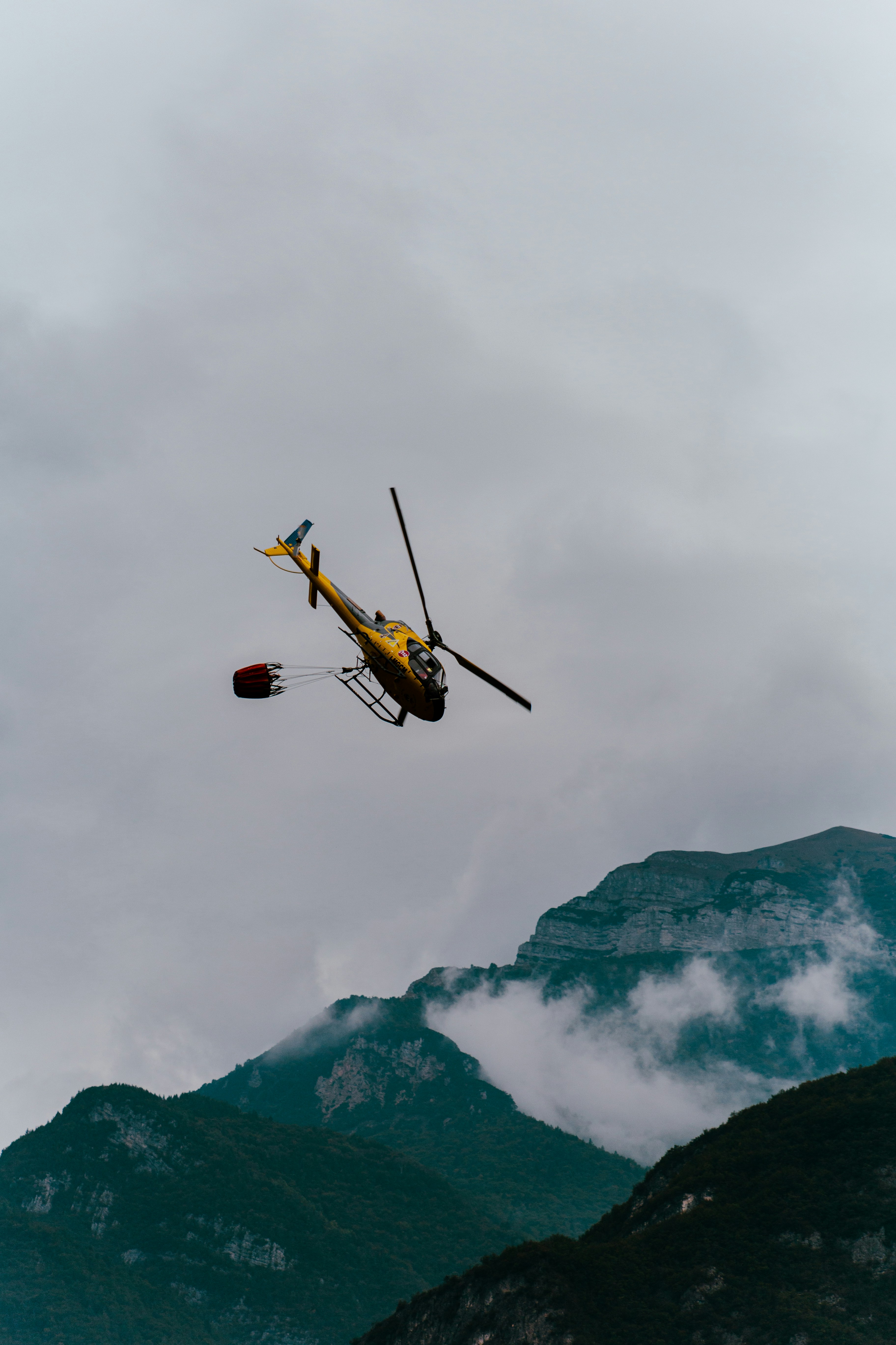 Un hélicoptère jaune survolant une montagne photo – Photo Trento ...