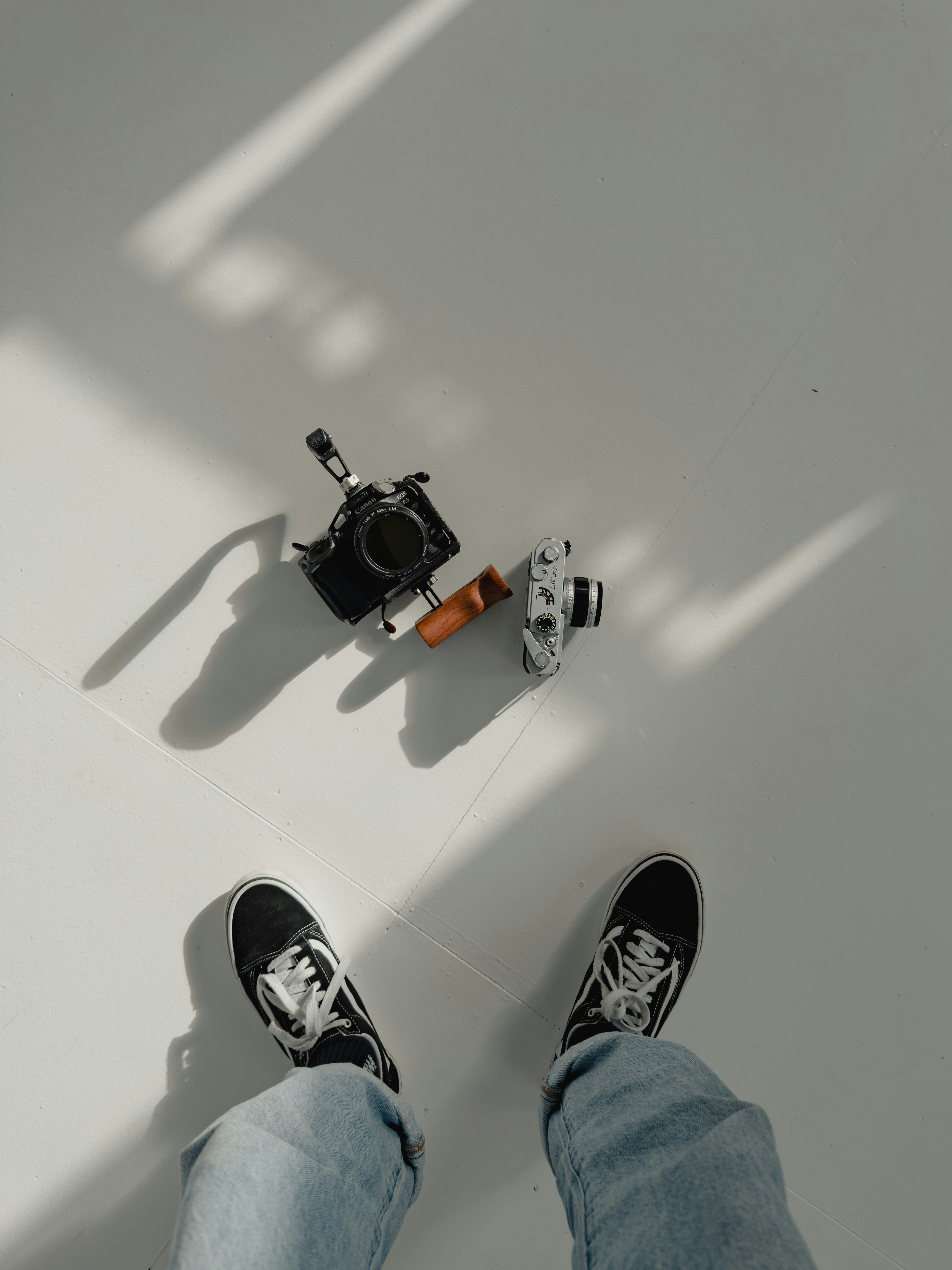 A person's feet and a camera on a white background photo – Free Grey ...