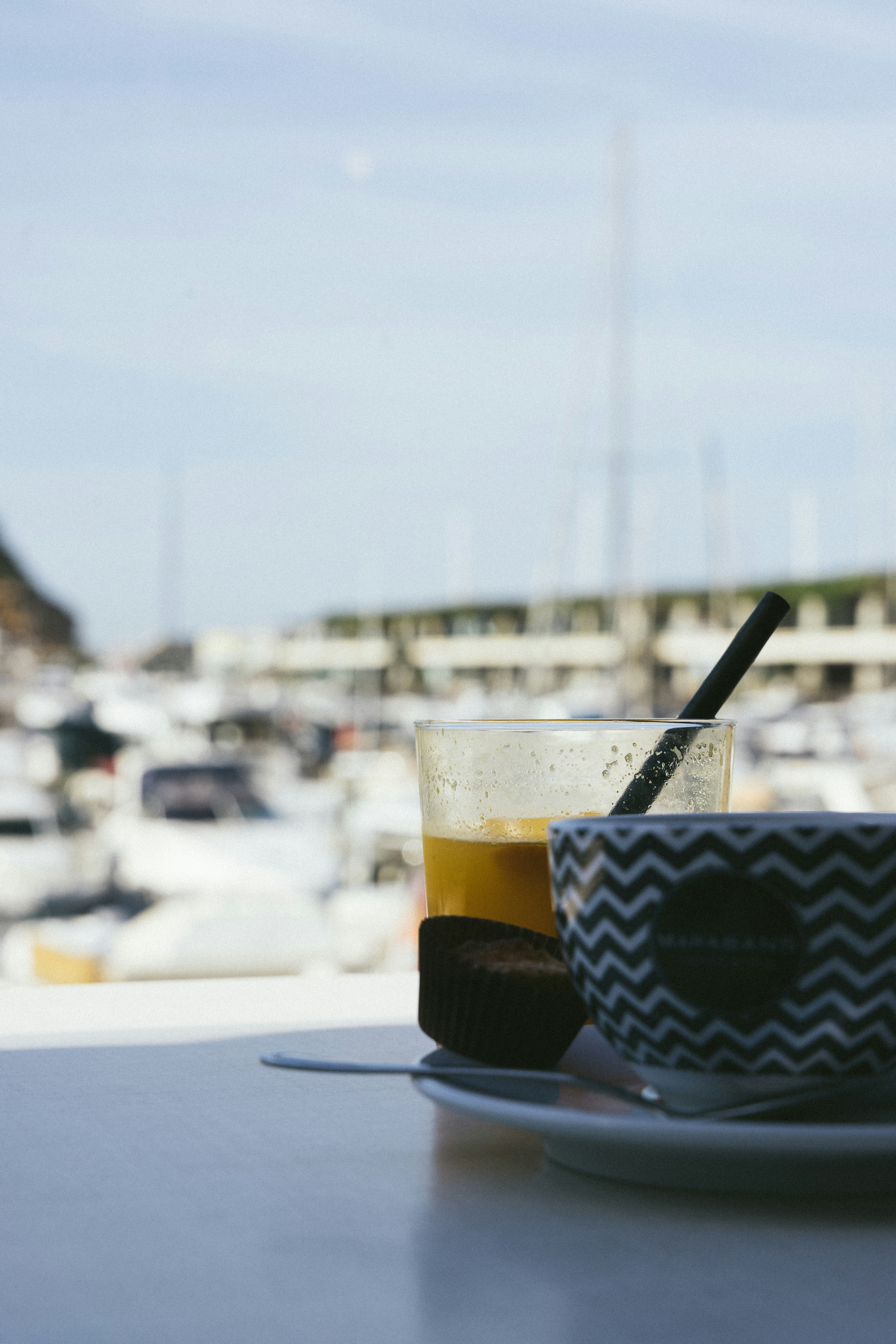 Citrus Moment at the Marina: Glass, Straw, and Zigzag Dish in Soft Focus