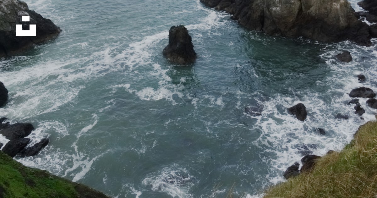 배경에 Pointe Du Raz가있는 배경에 수역이있는 바위 해변 사진 Unsplash의 무료 바닷가 이미지