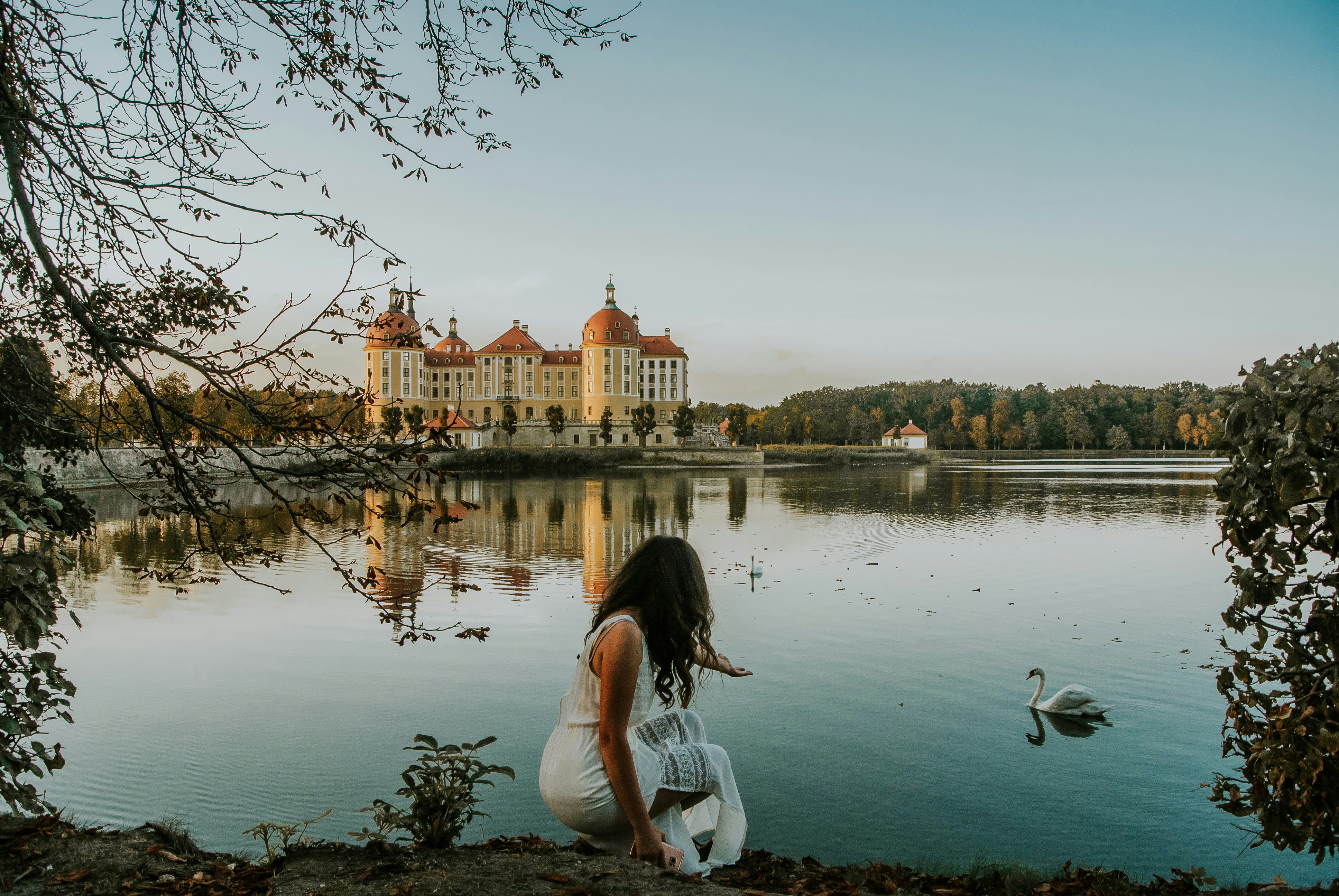 Lakeside Reverie: A Solitary Figure by the Castle-Reflected Lake