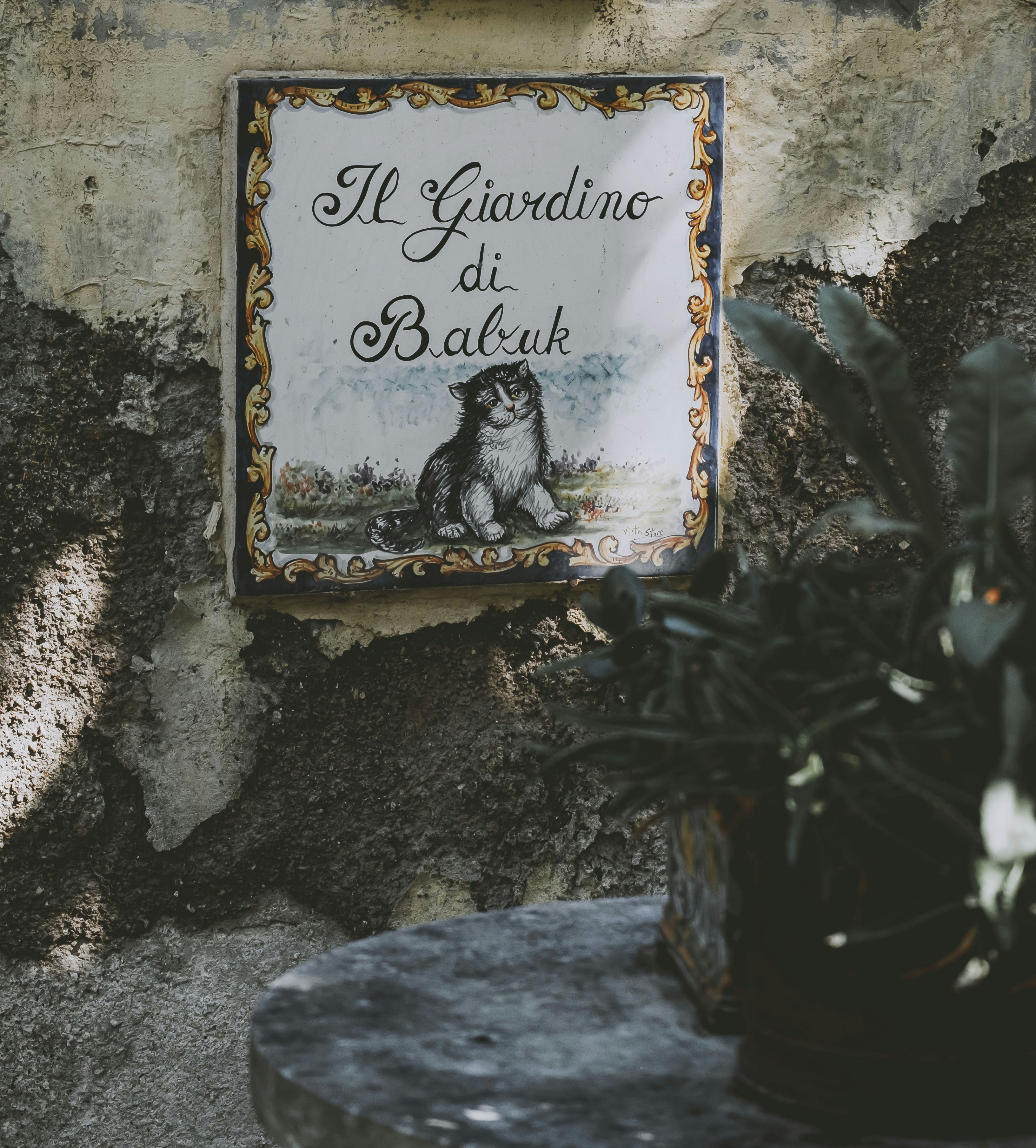 Il Giardino di Balzuk: Weathered Ceramic Tile Amid Stone and Foliage