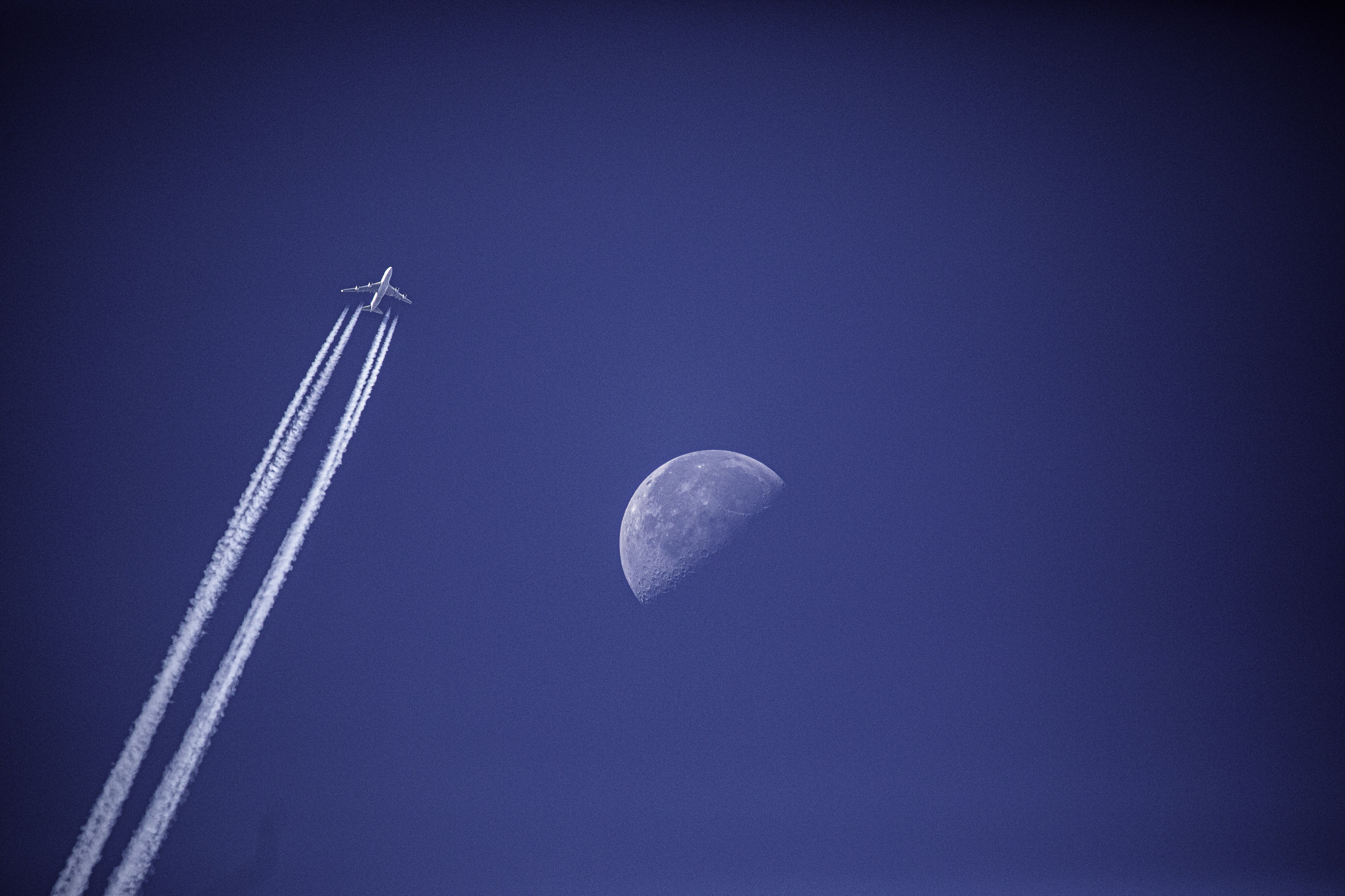 Moonlight and Contrails Over an Indigo Sky