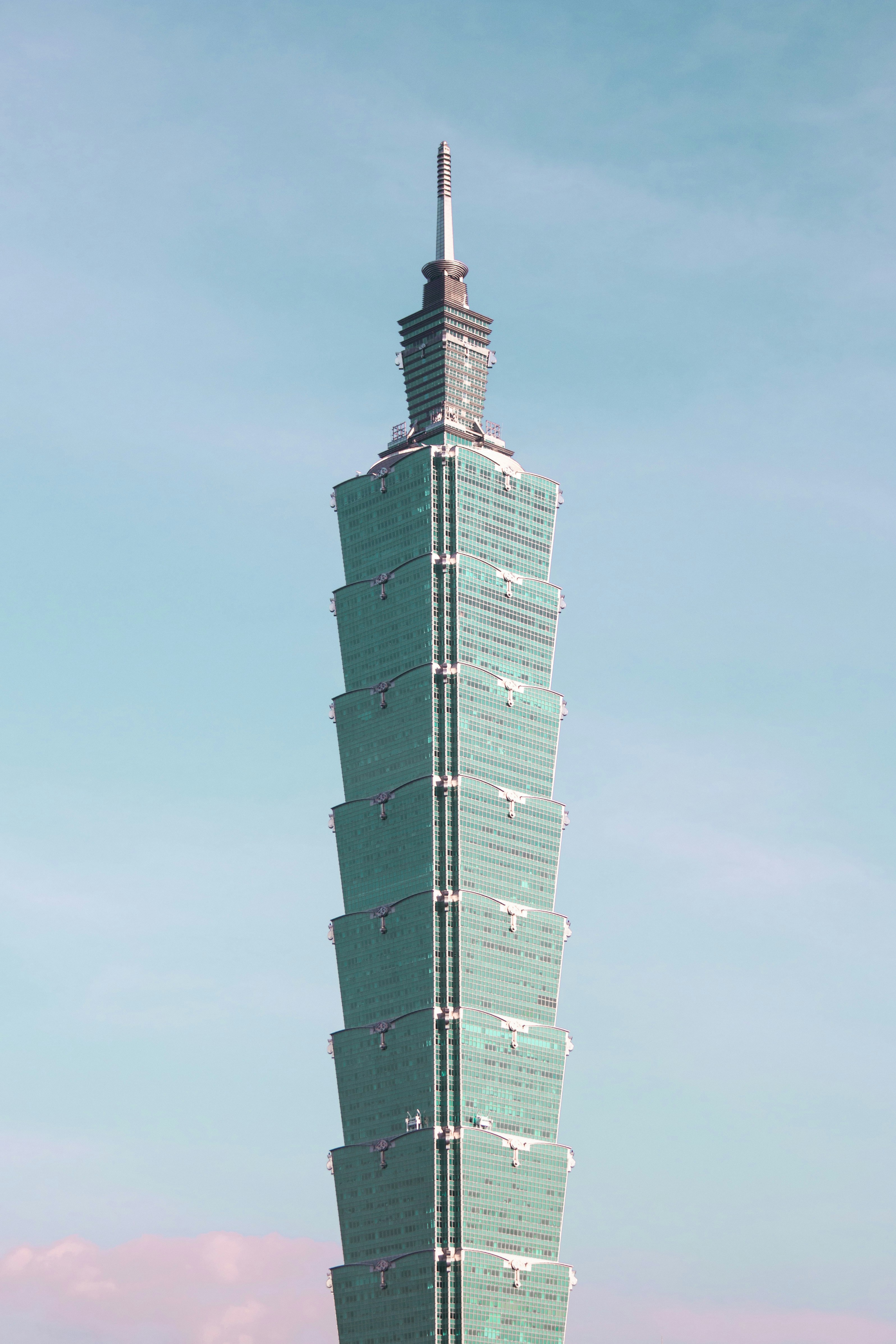 A tall building with a blue sky with Taipei 101 in the background photo ...
