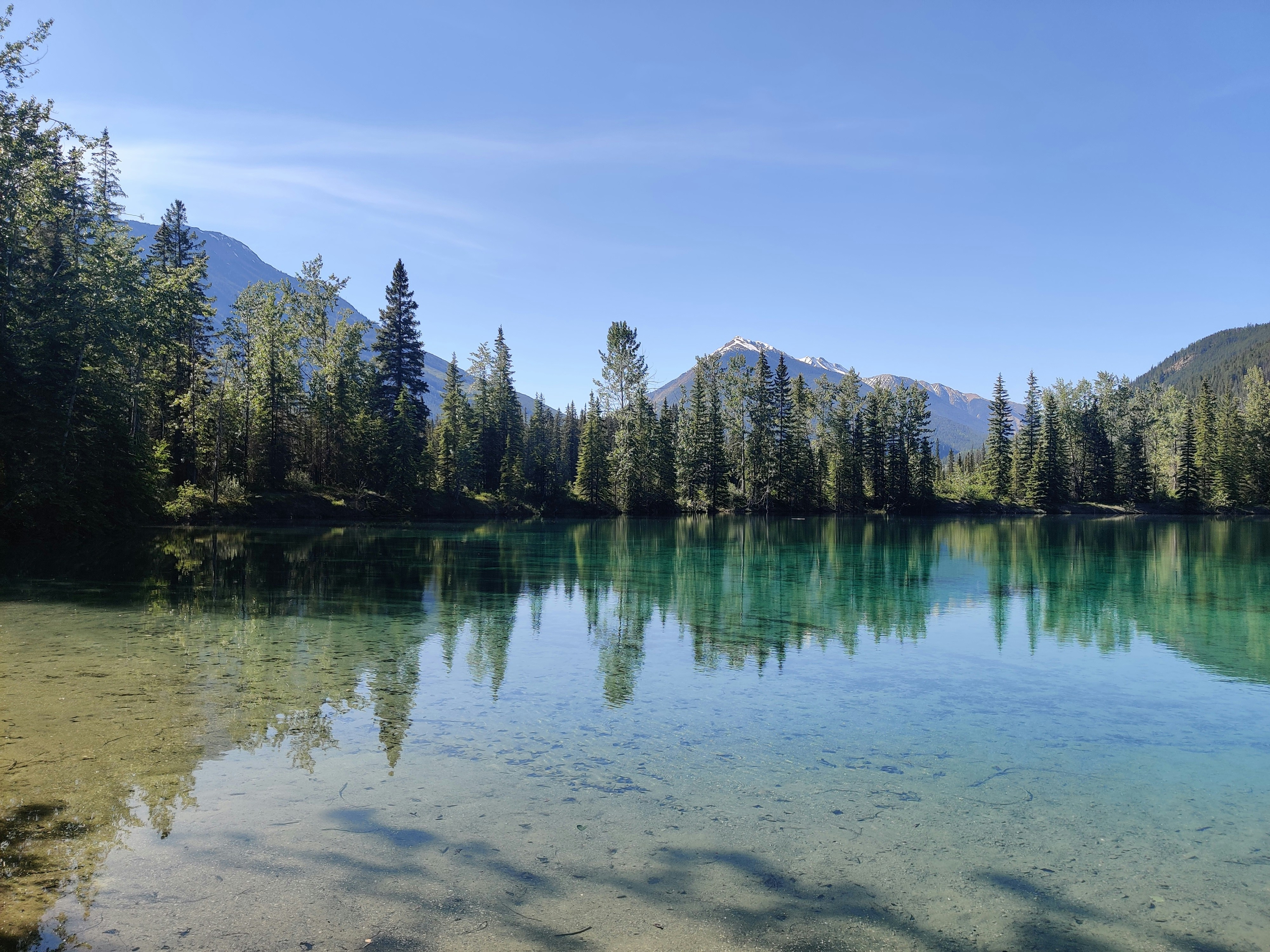 A lake with trees and mountains in the background photo – Free Faeder ...