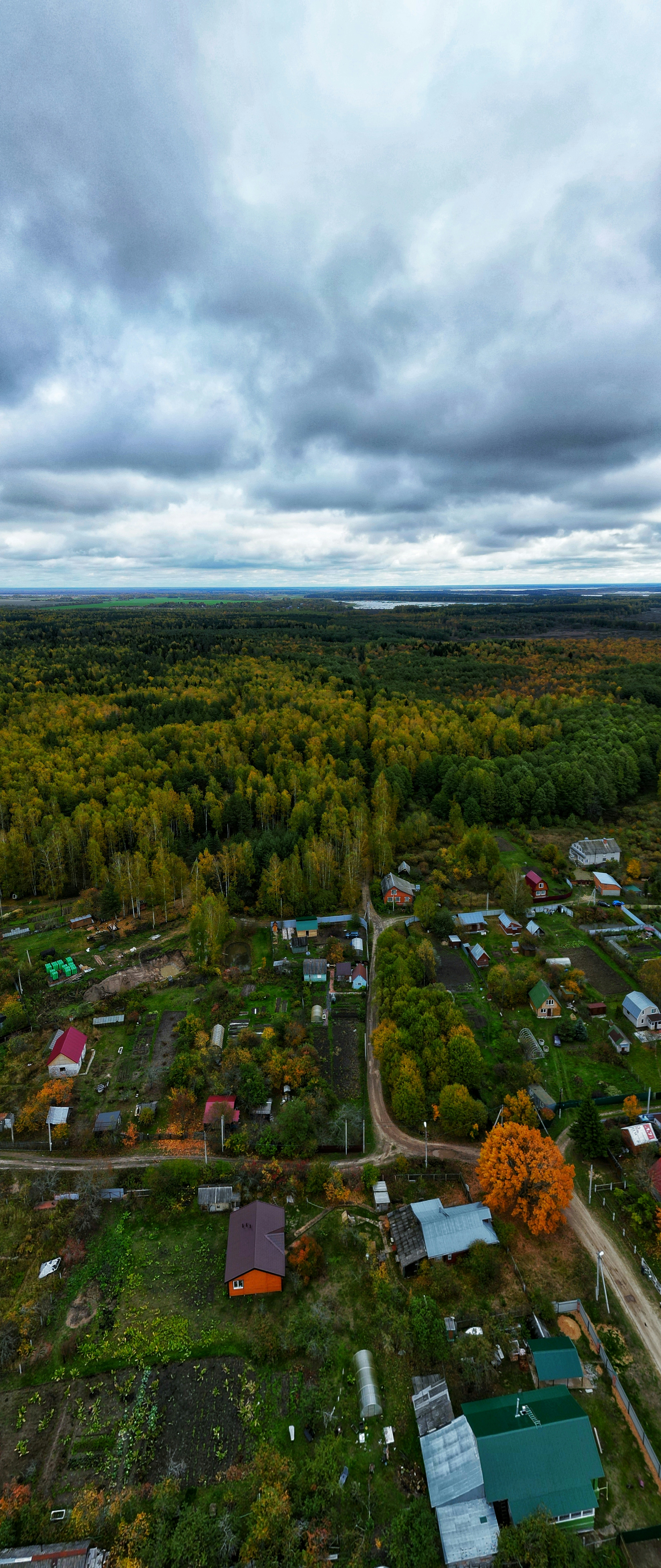 Autumn Mosaic from Above: A Quiet Village Beneath Turbulent Clouds