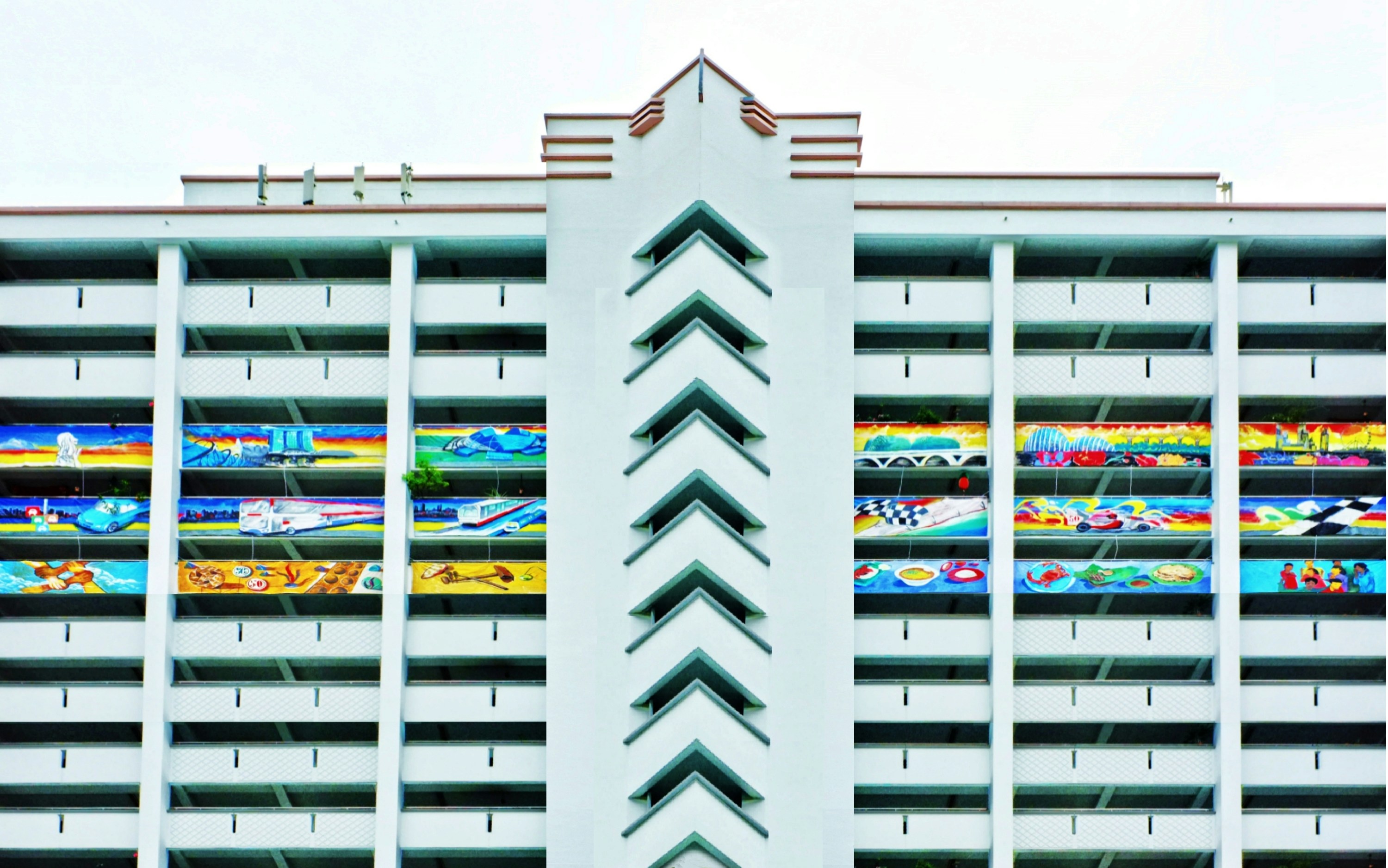Central Spine in Color: Rainbow Banners Framing a Modernist Parking Facade