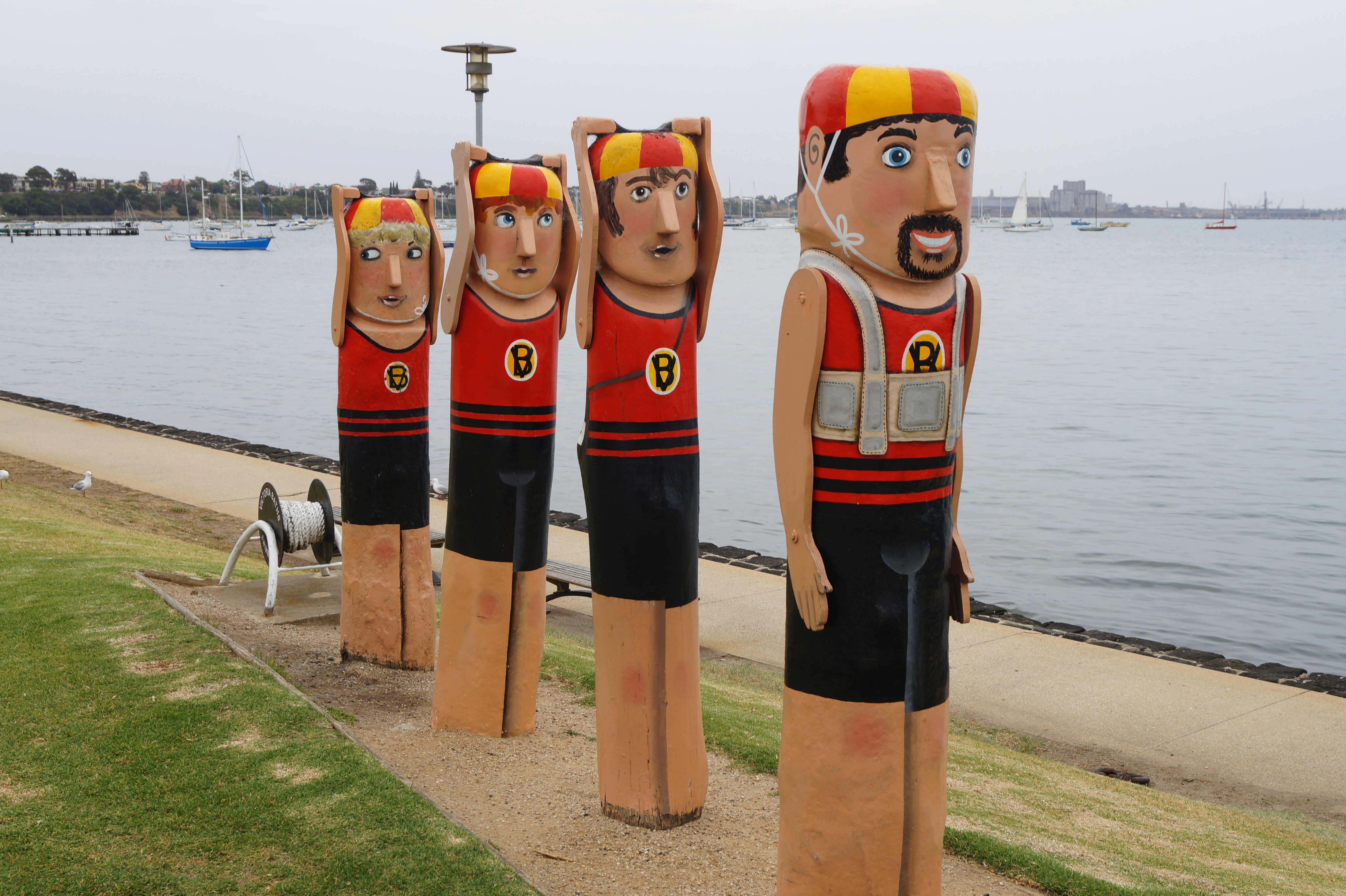 A group of statues of people in clothing by the water photo – Free ...
