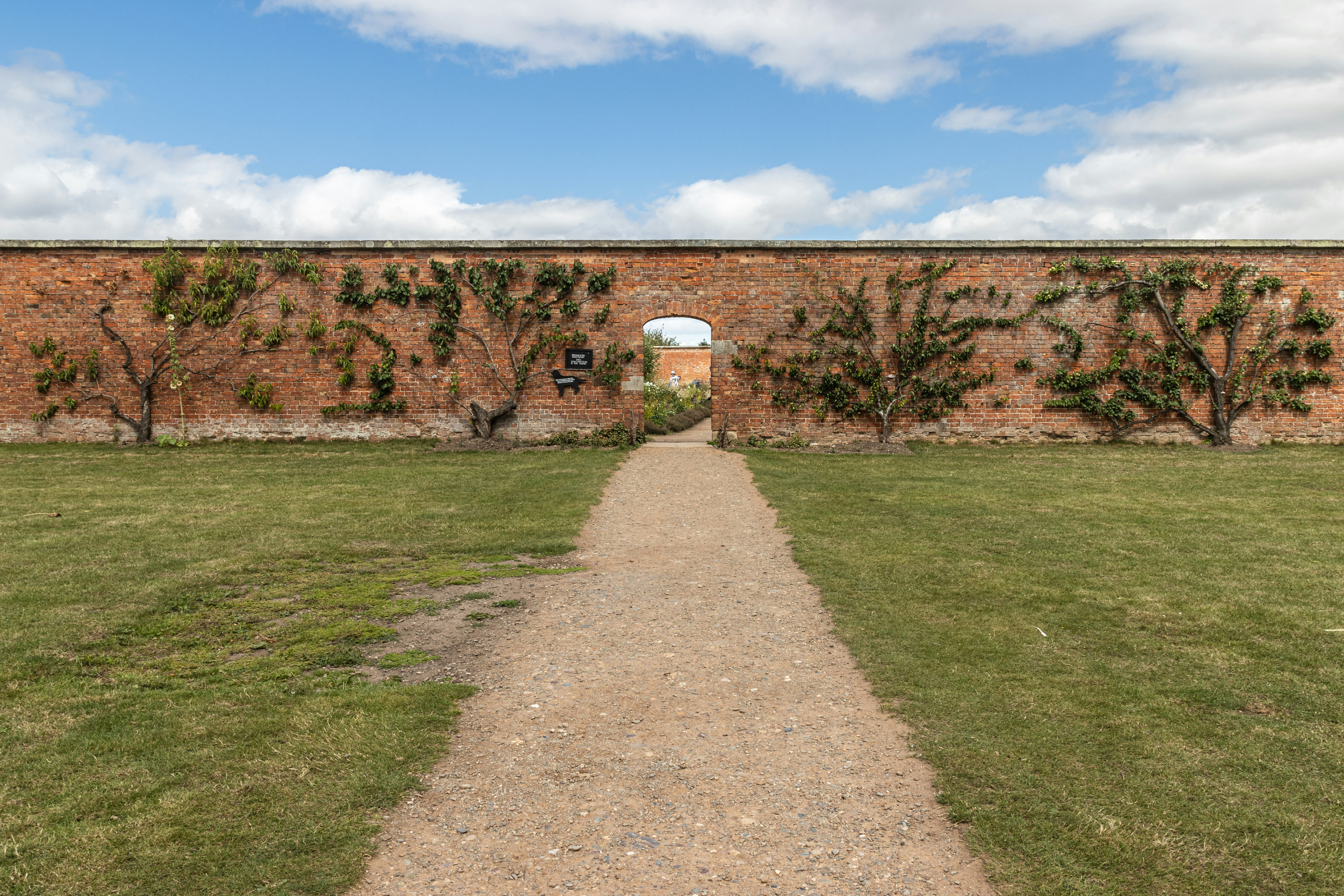 a path leading to a brick building