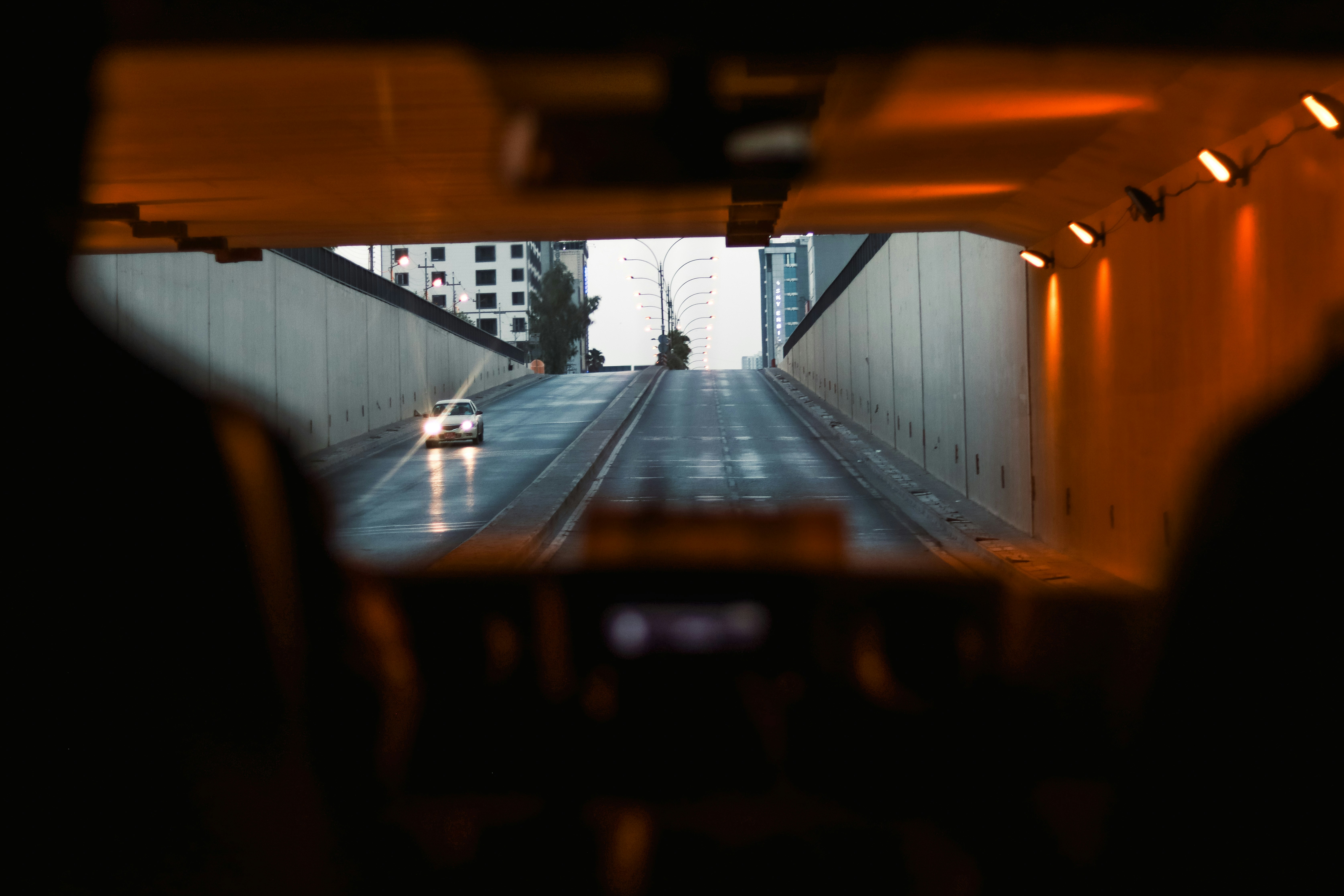 Headlights in a Concrete Channel: Evening Descent from the City Tunnel
