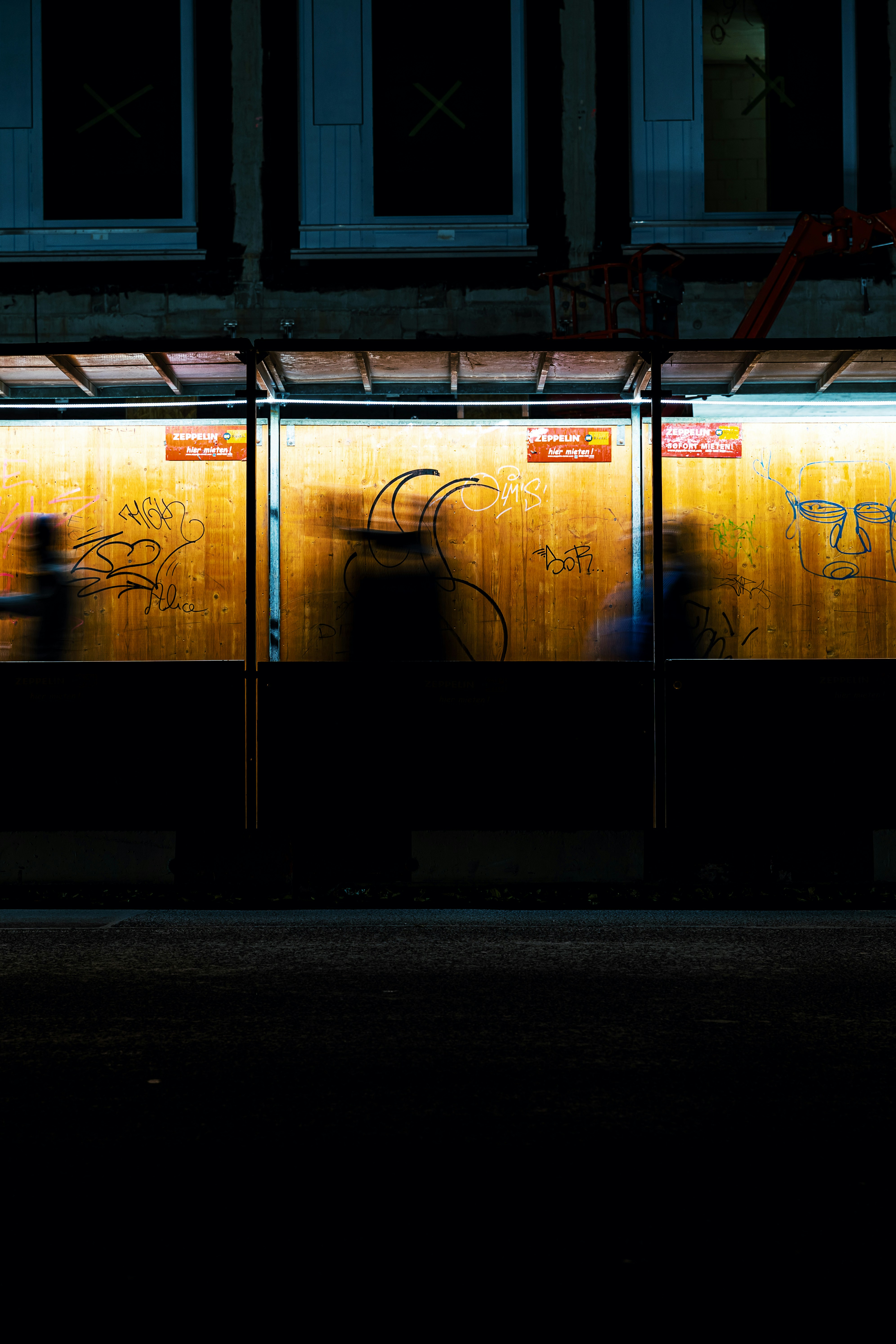 A person standing in front of a building with graffiti on it photo ...