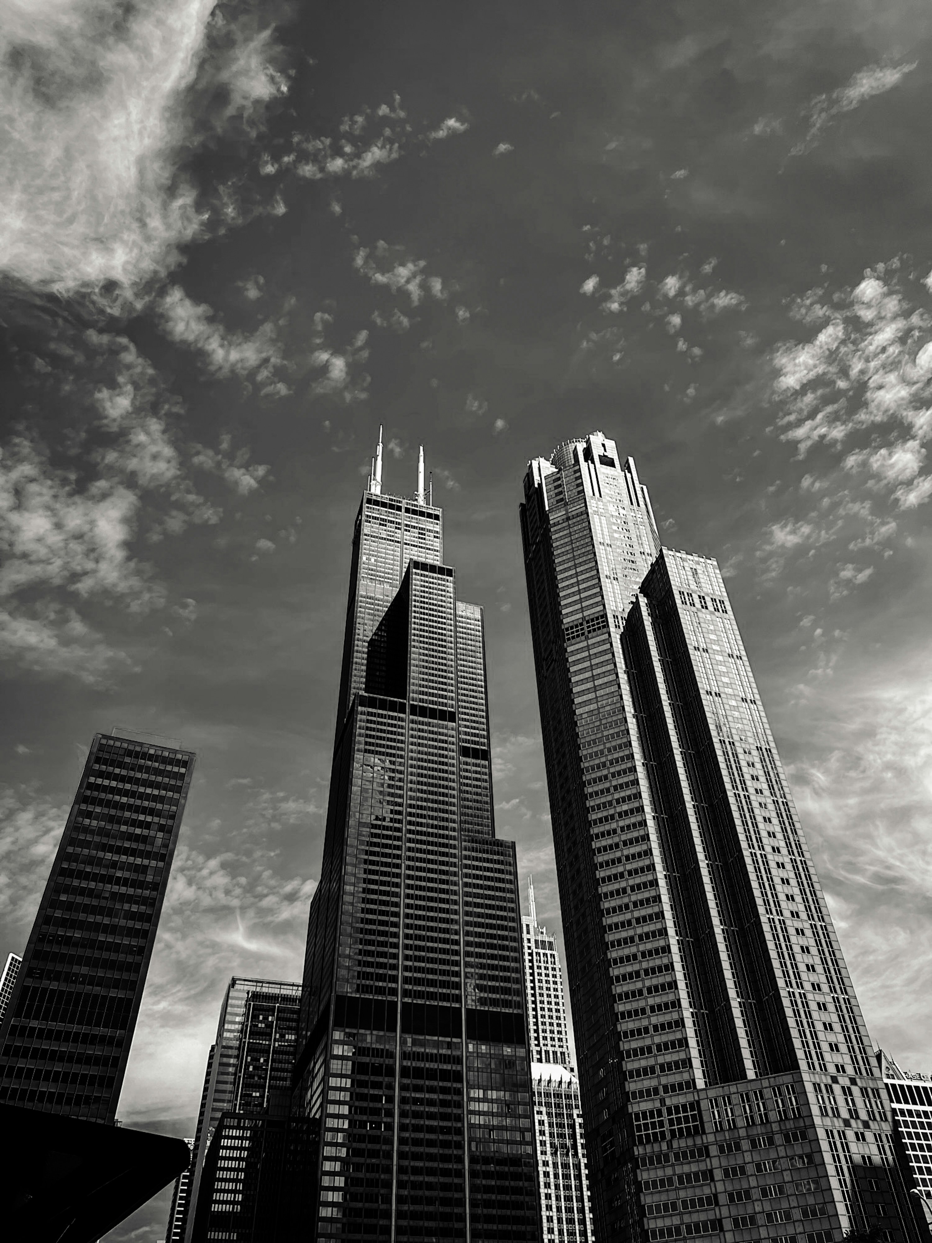 Monochrome Ascension: Twin Towers Piercing a Clouded Sky