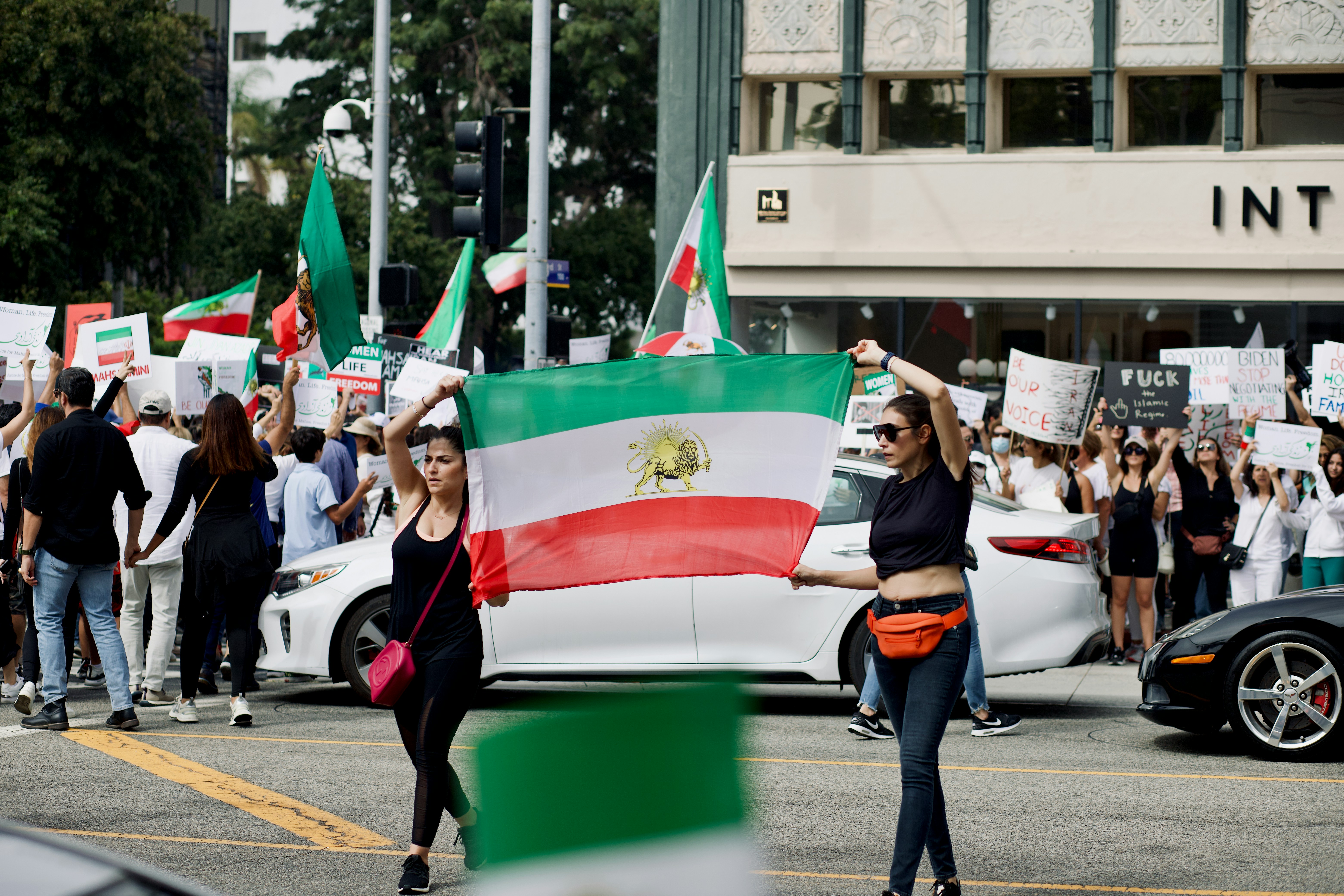 A group of people holding flags and walking on the street photo – Free ...