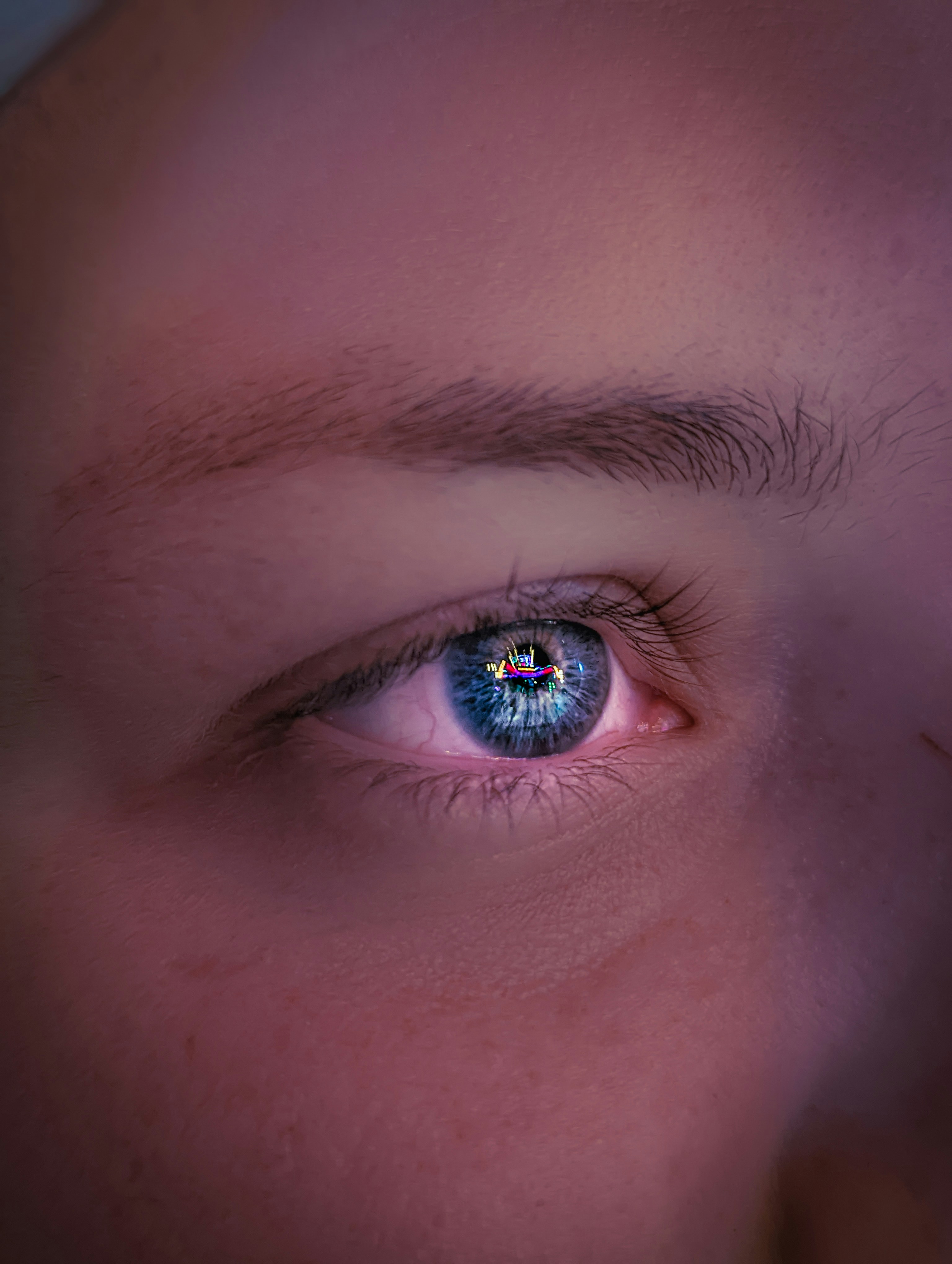 Close-up of a human eye reflecting a vibrant scene, showcasing intricate details in the iris and pupil. The reflection adds a layer of narrative depth.