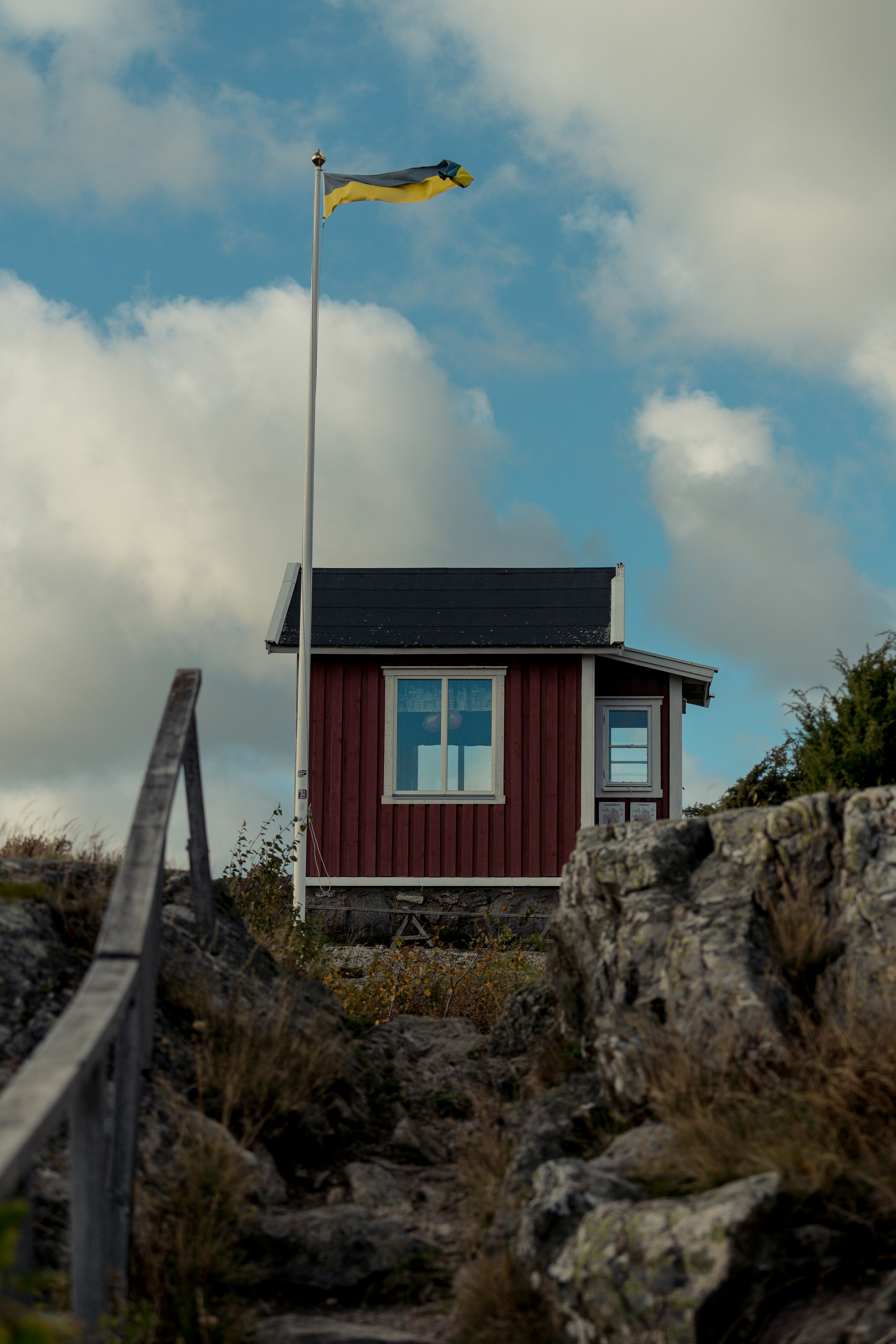 Flag Over a Coastal Red Cabin