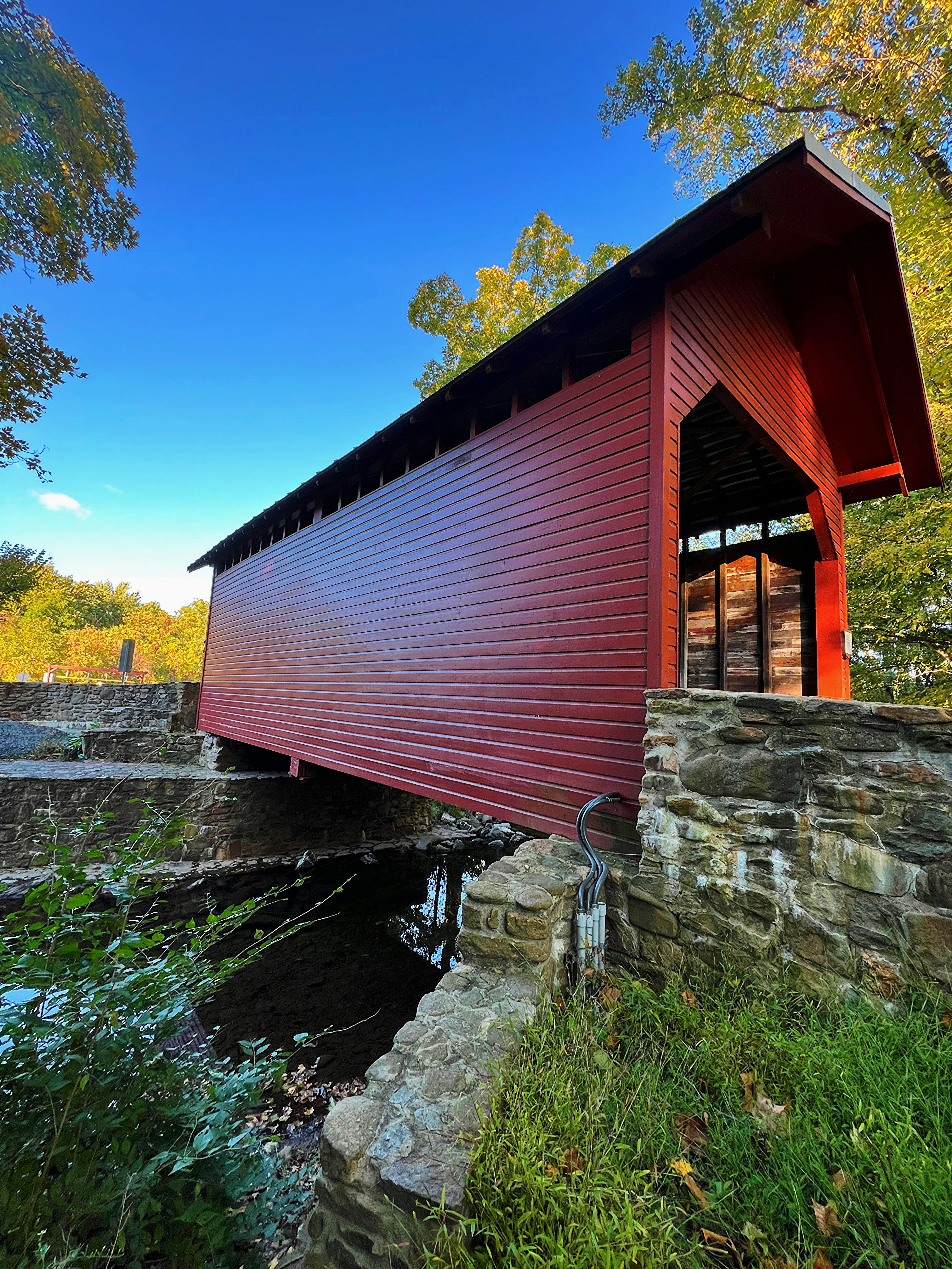 Un edificio rojo con un estanque frente a él foto – Imagen de Roddy Rd ...