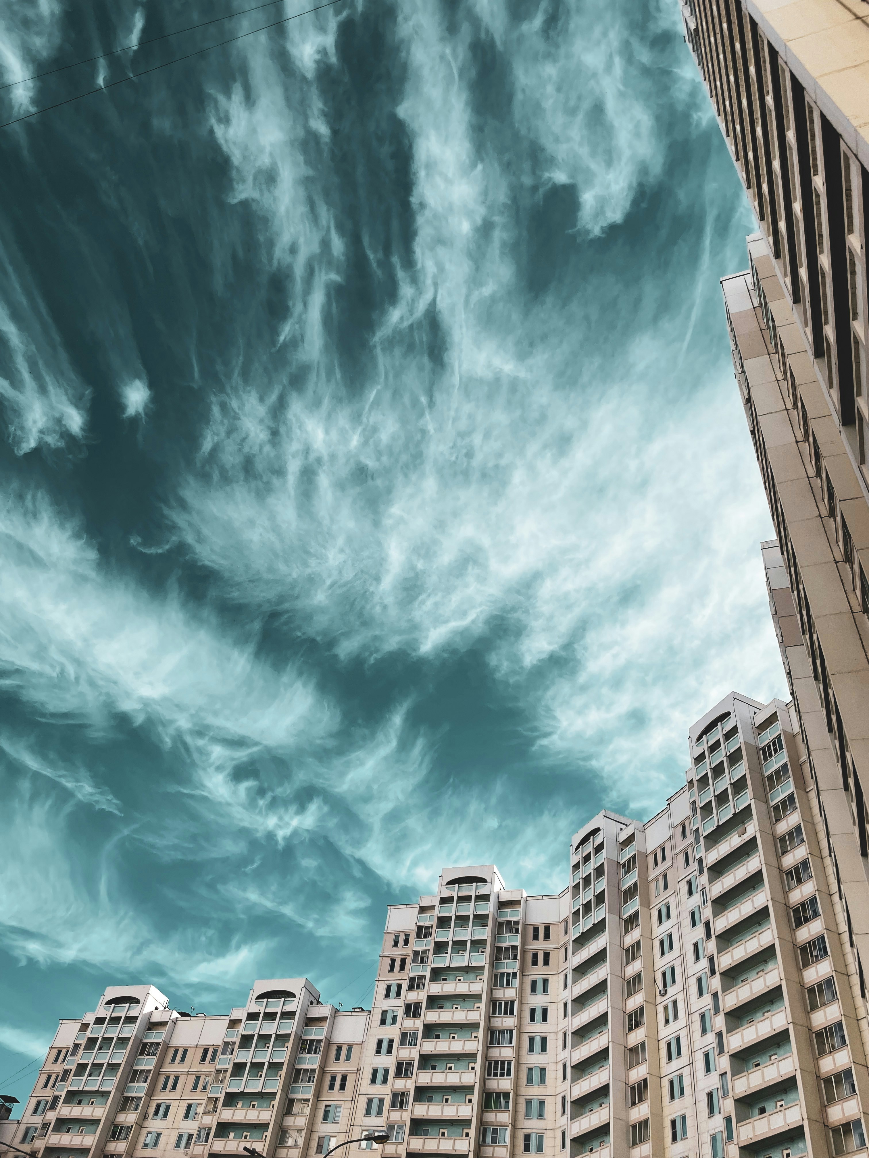 Teal Sky Over Tiered Towers: An Upward Cityscape