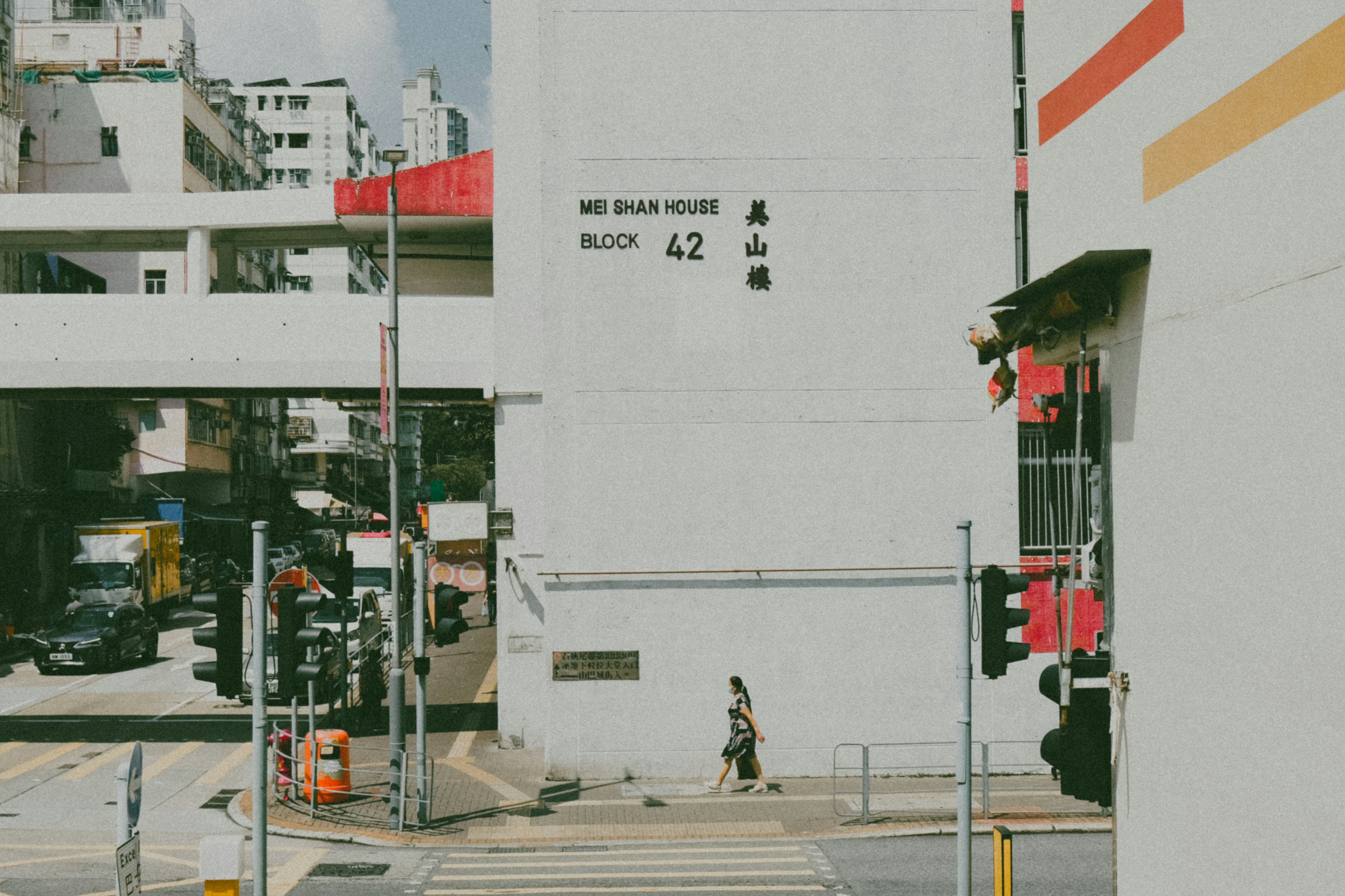 Mei Shan House, Hong Kong | a person walking on a sidewalk