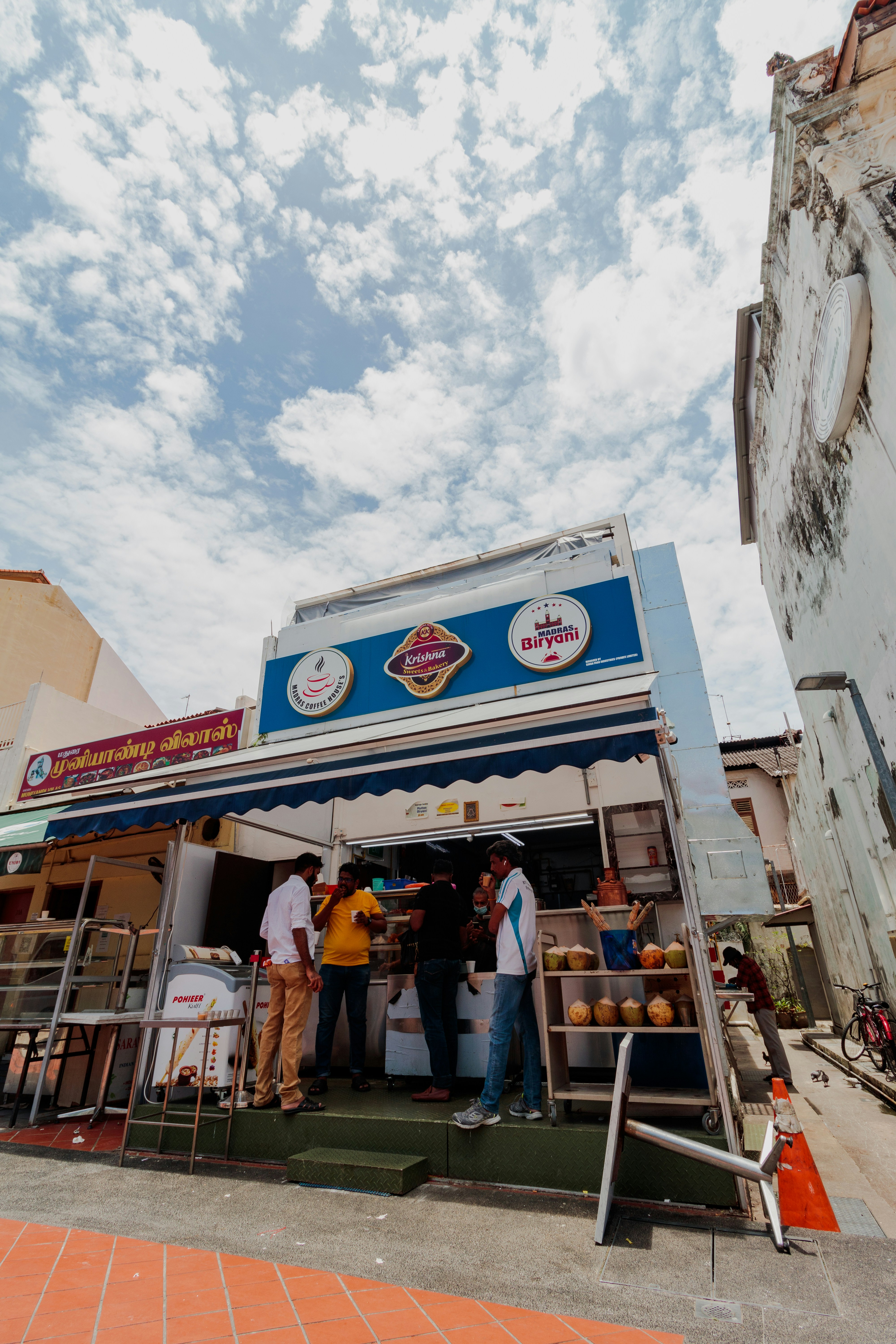 A group of people stand outside a shop photo – Free Singapore Image on ...