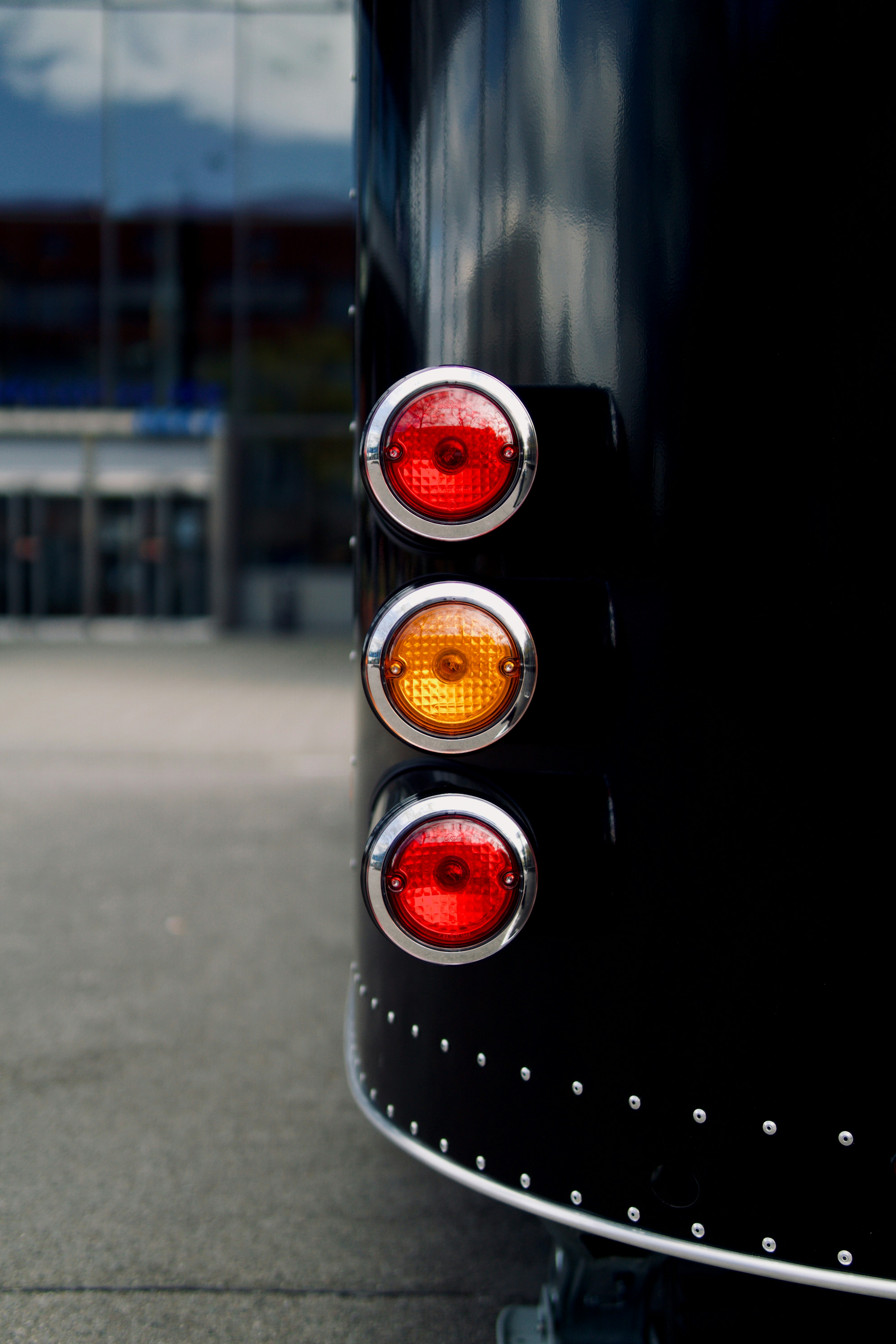 Tail Lights on a Black Train Car at the Edge of an Urban Plaza