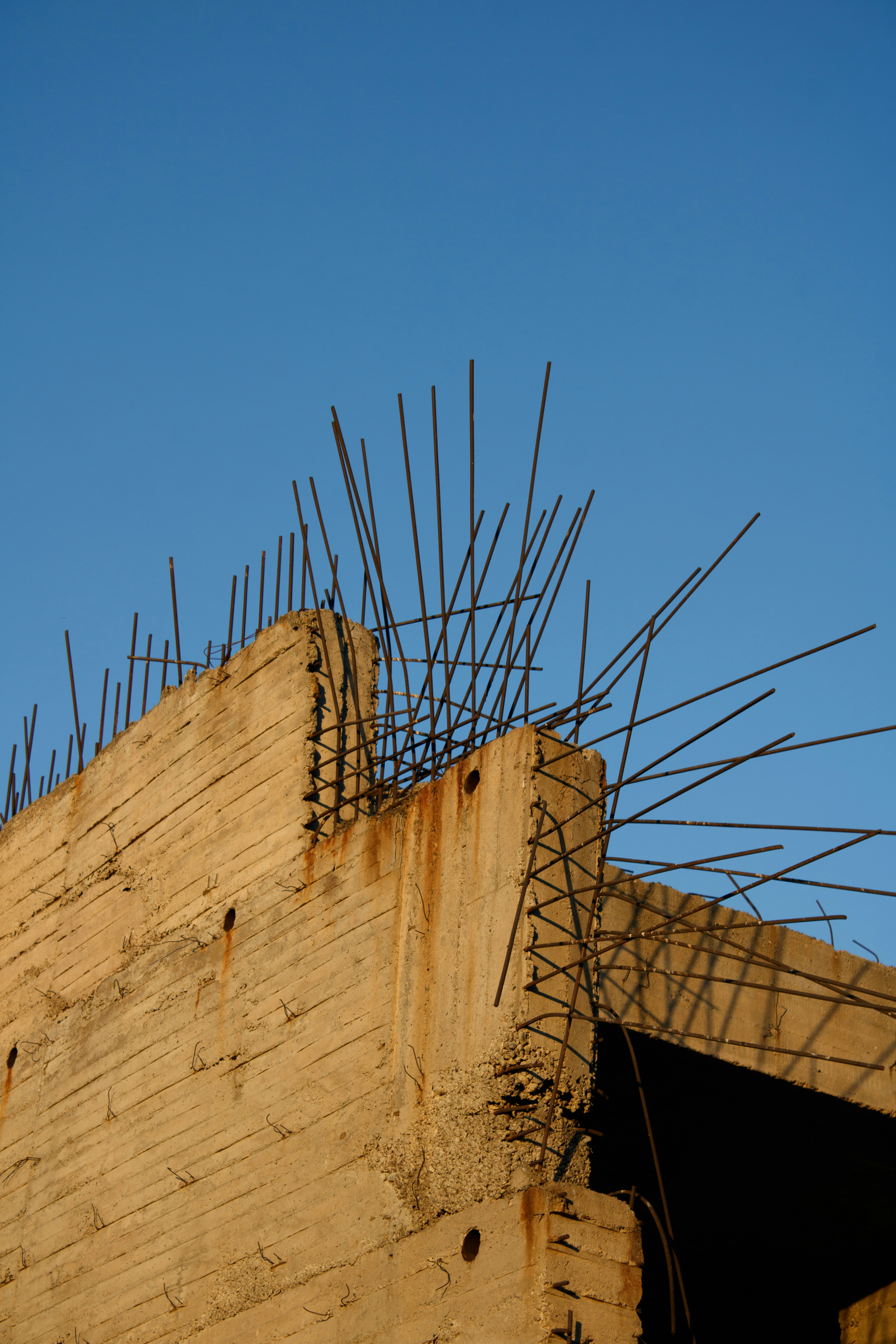 Rust Crown Rising from a Weathered Concrete Edge Against a Clear Azure Sky