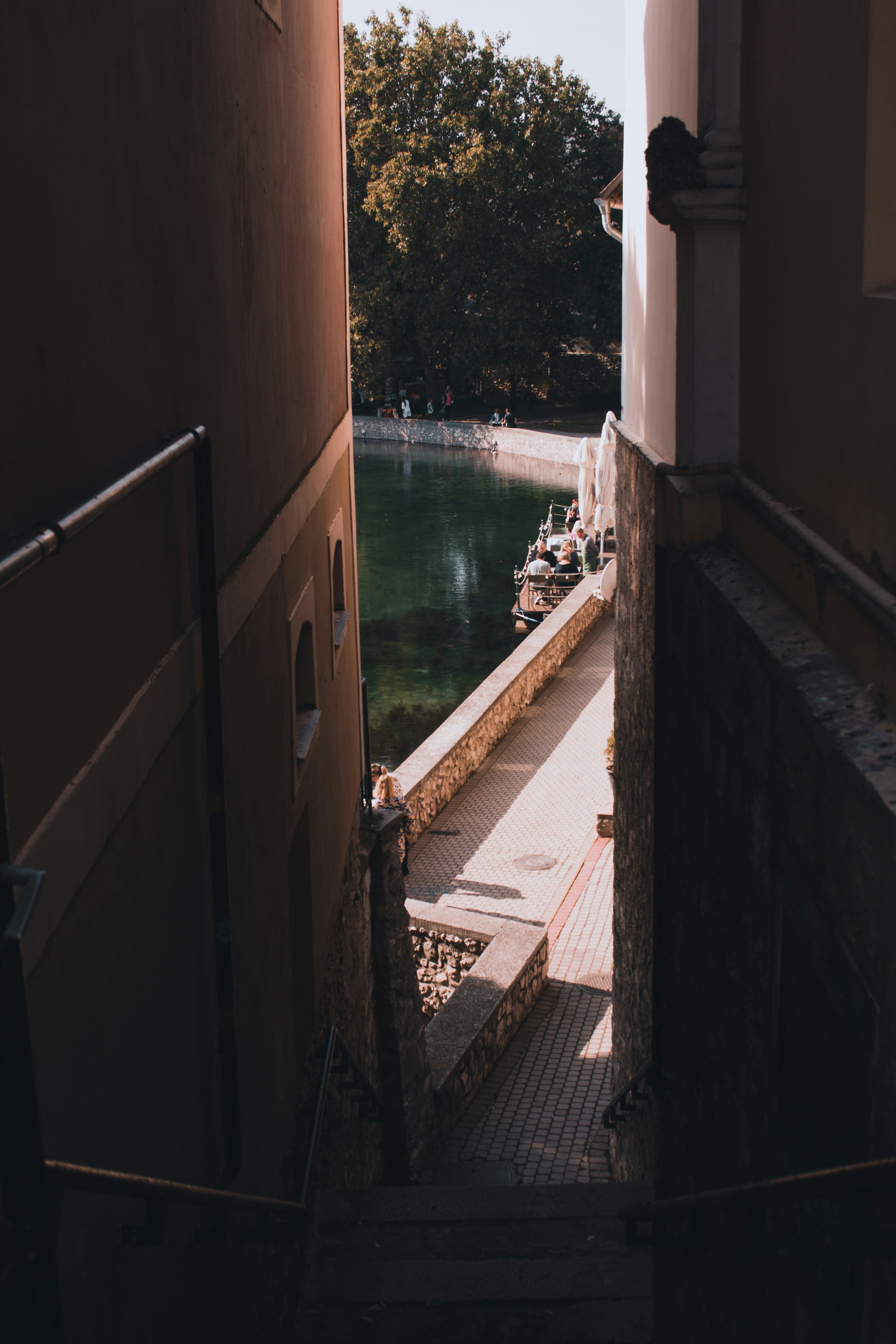 Staircase to the Canal: Sunlit Path Between Brick Walls