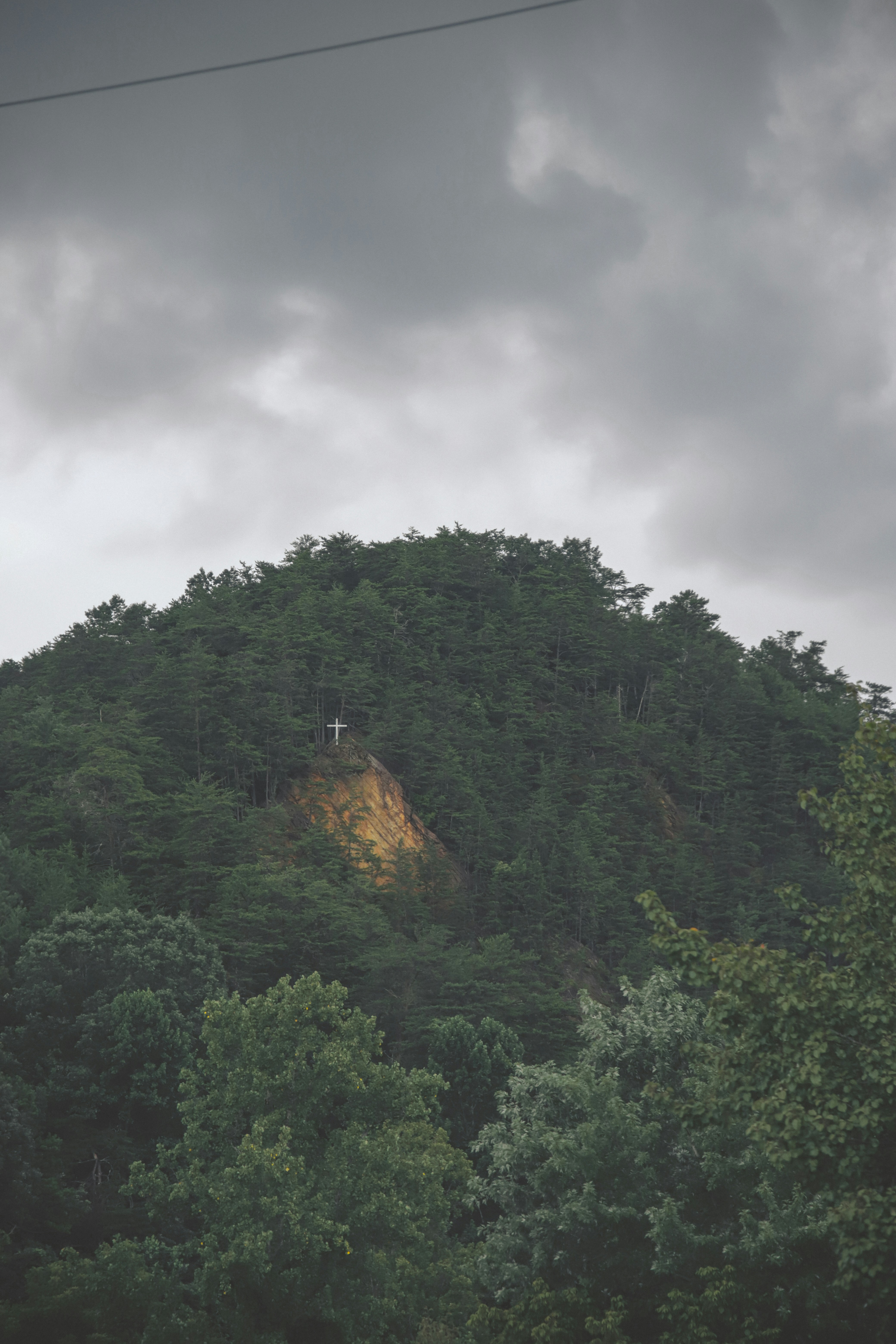 Cruciform Beacon Crest: A Cross on the Pine-Clad Cliff