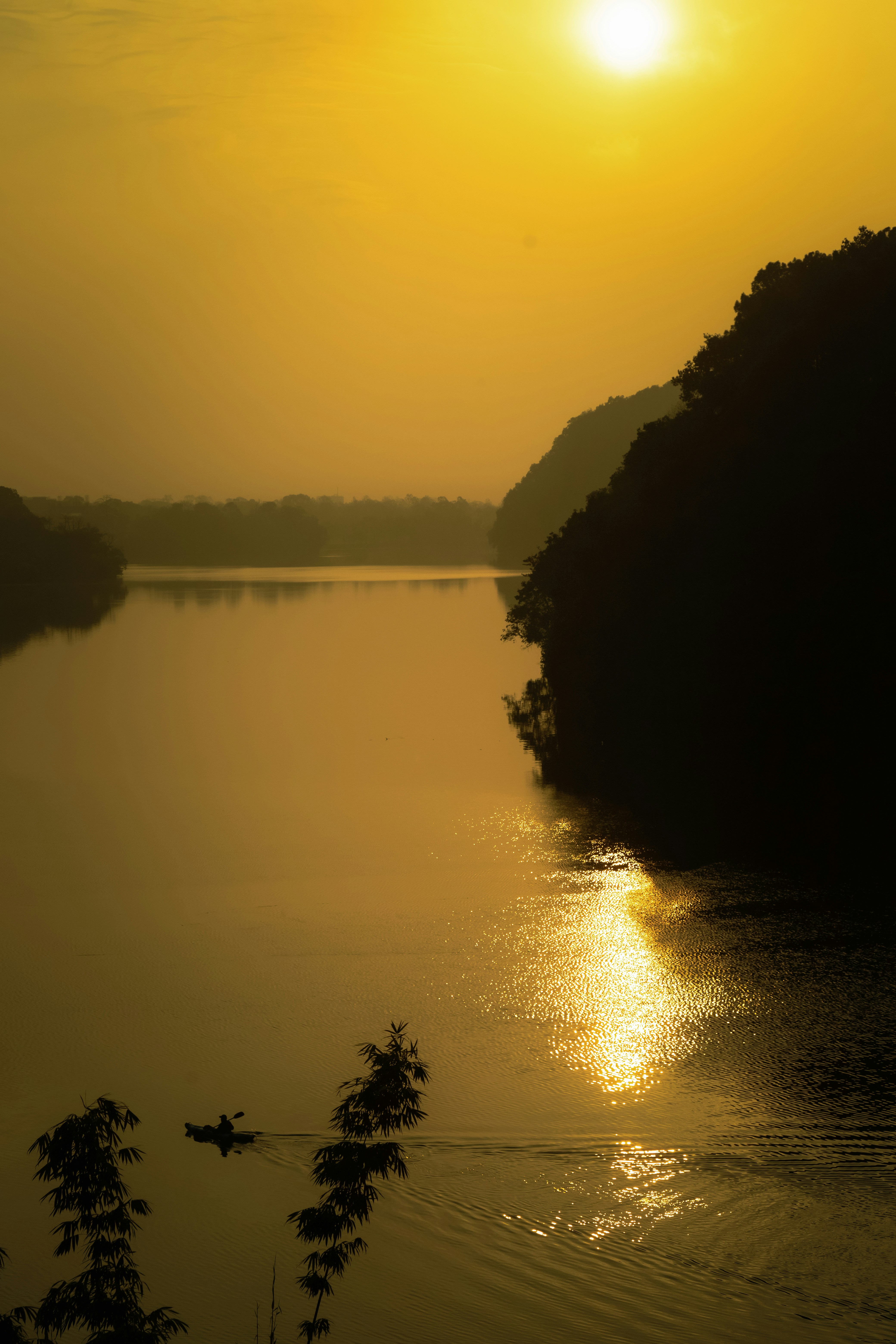 a body of water with trees and hills around it