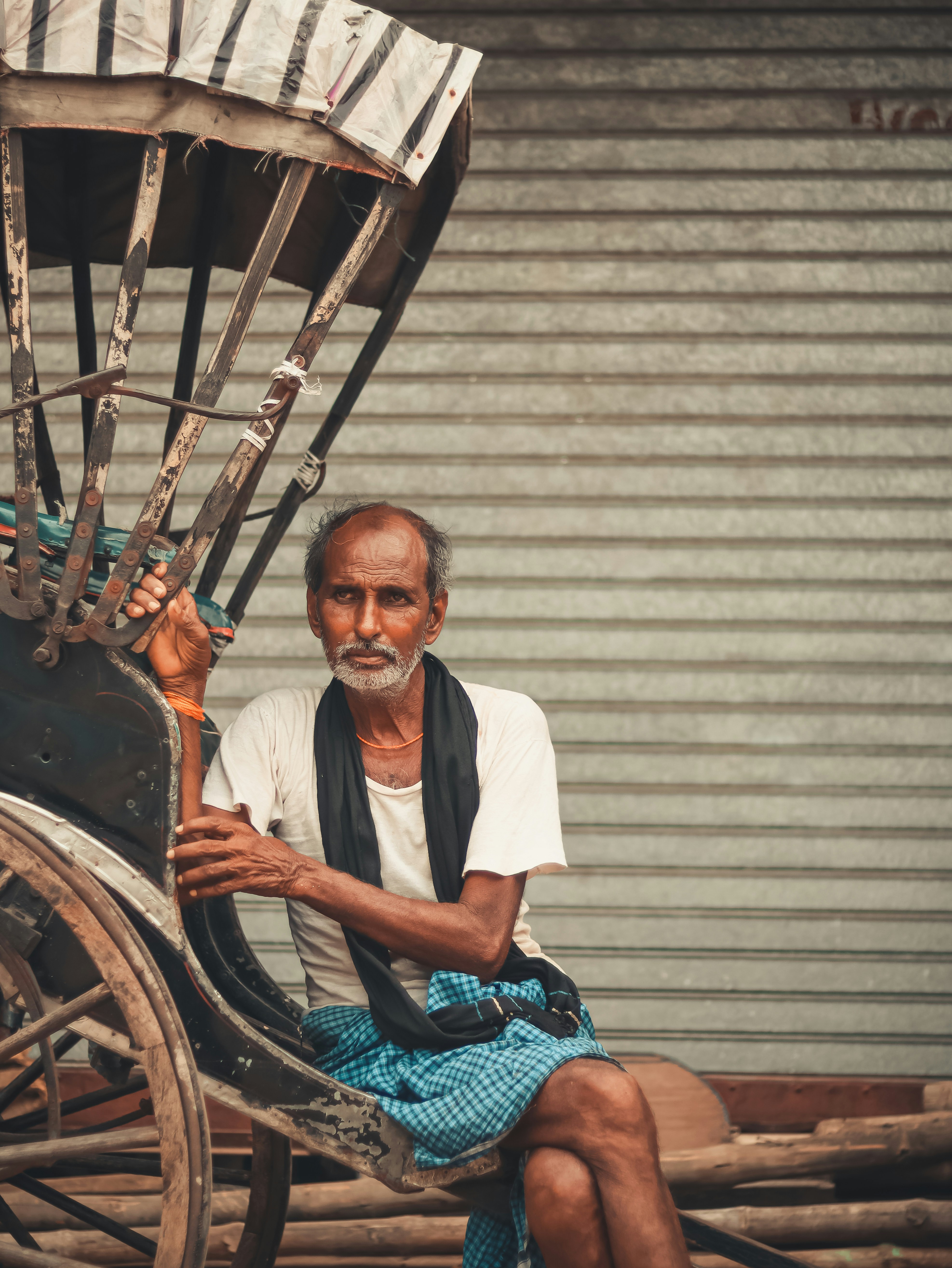 Quiet Resolve by the Corrugated Street: Portrait of a Rickshaw Driver