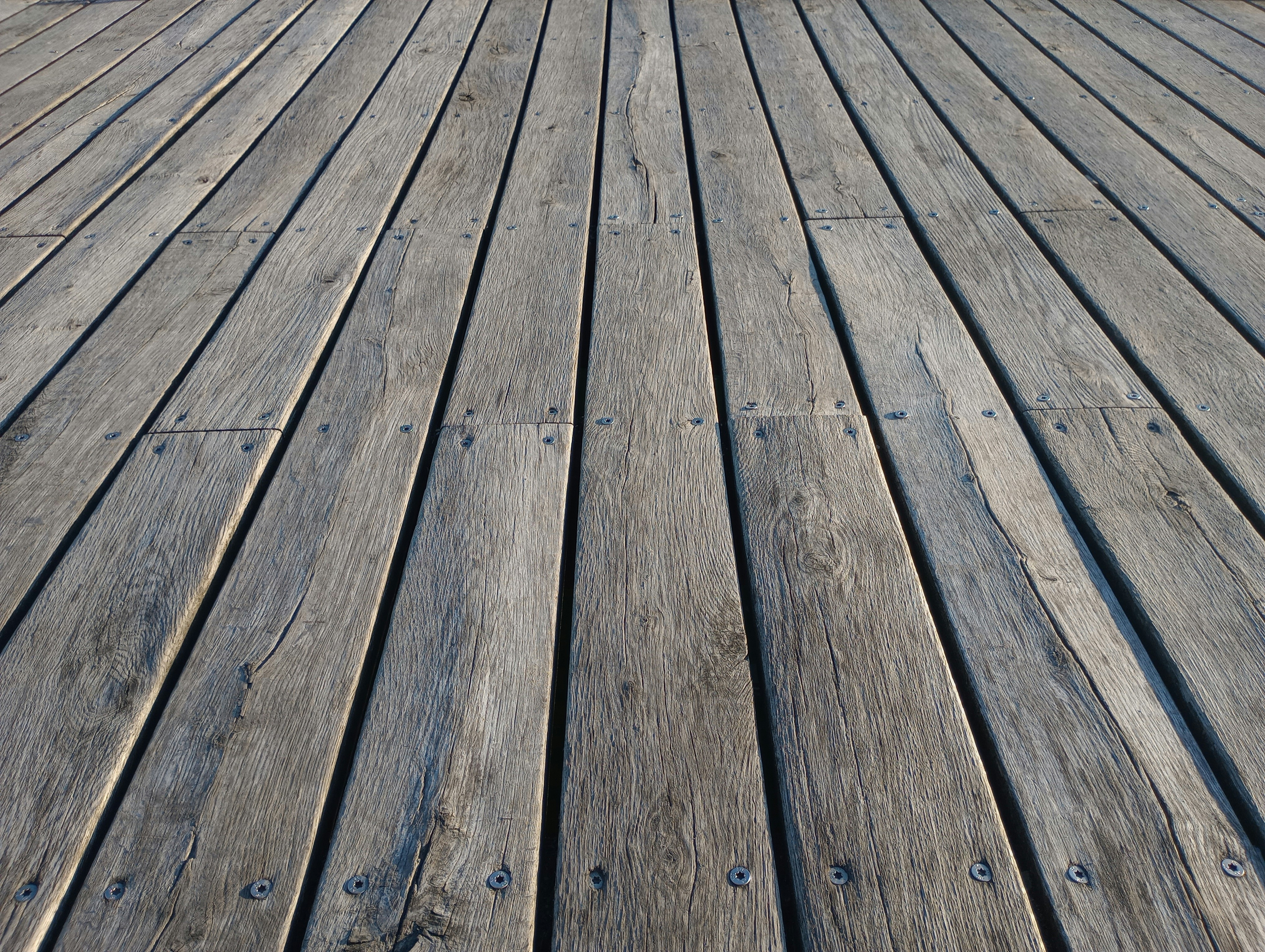 Close-up view of weathered wooden planks arranged in a curved pattern, showcasing the texture and aging of the material.