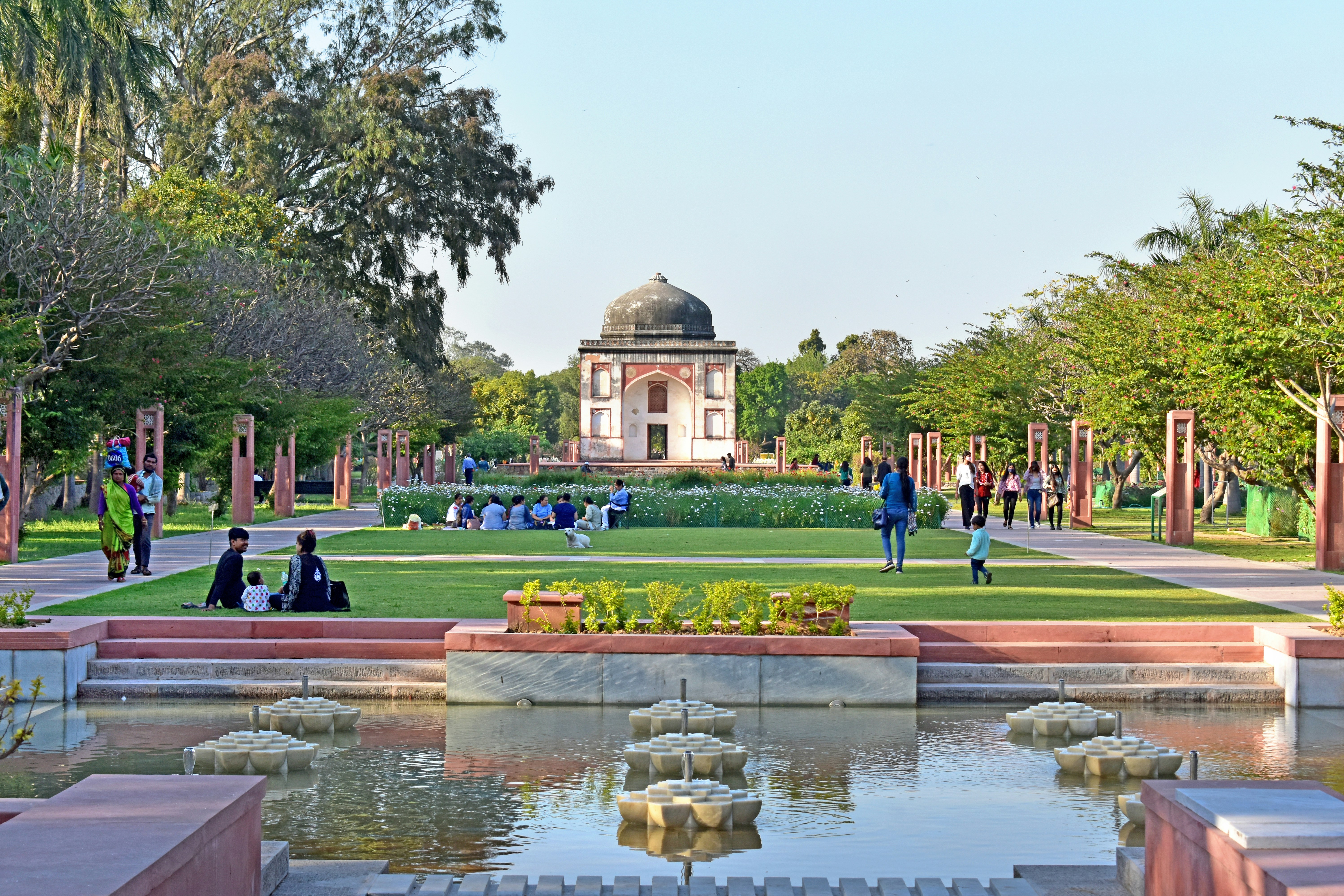 Marble lotus fountains with a historic structure in the background at Sunder Nursery, New Delhi.